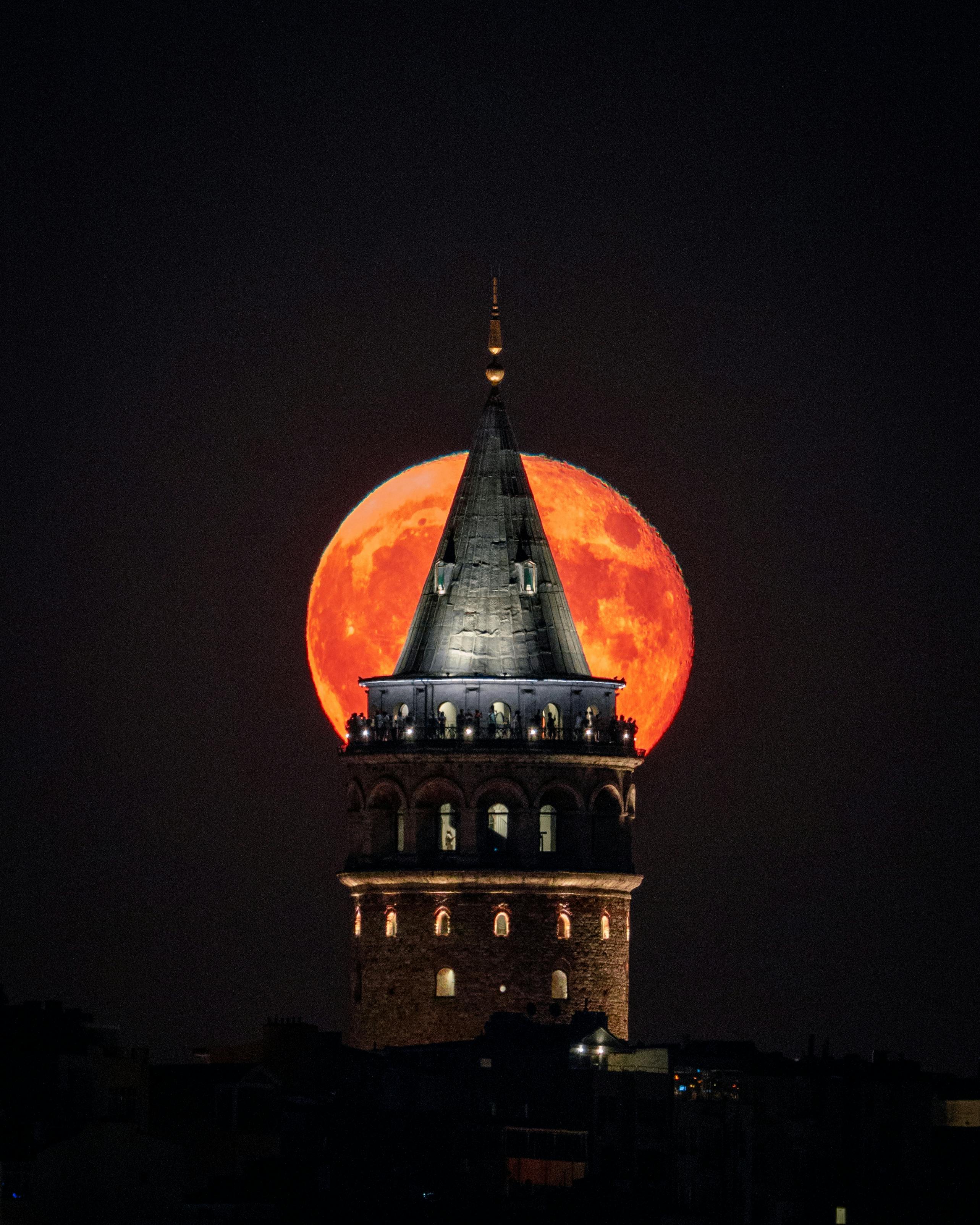 View of the Galata Tower against a Large Red Moon in Istanbul, Turkey ...
