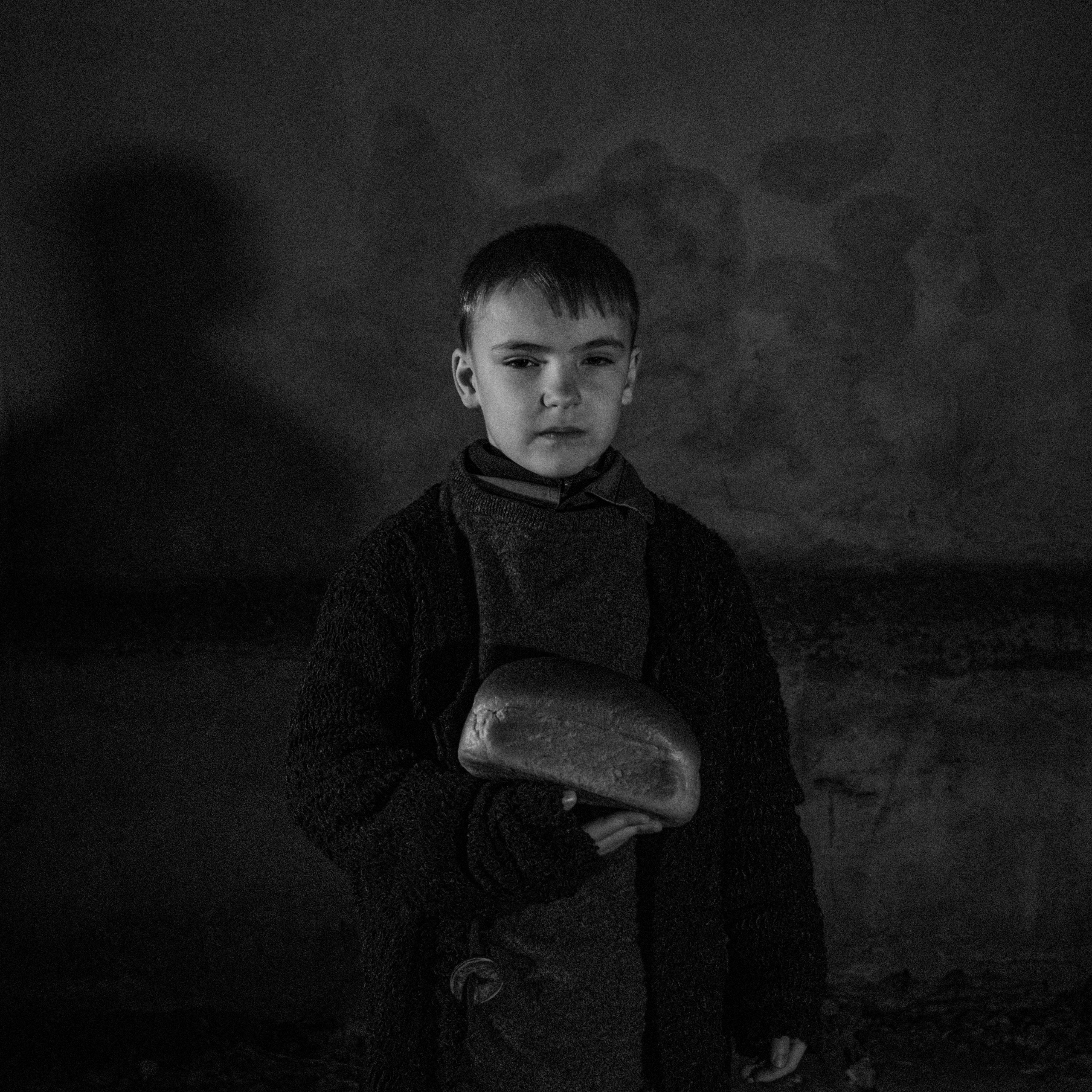 Boy Holding a Loaf of Bread · Free Stock Photo