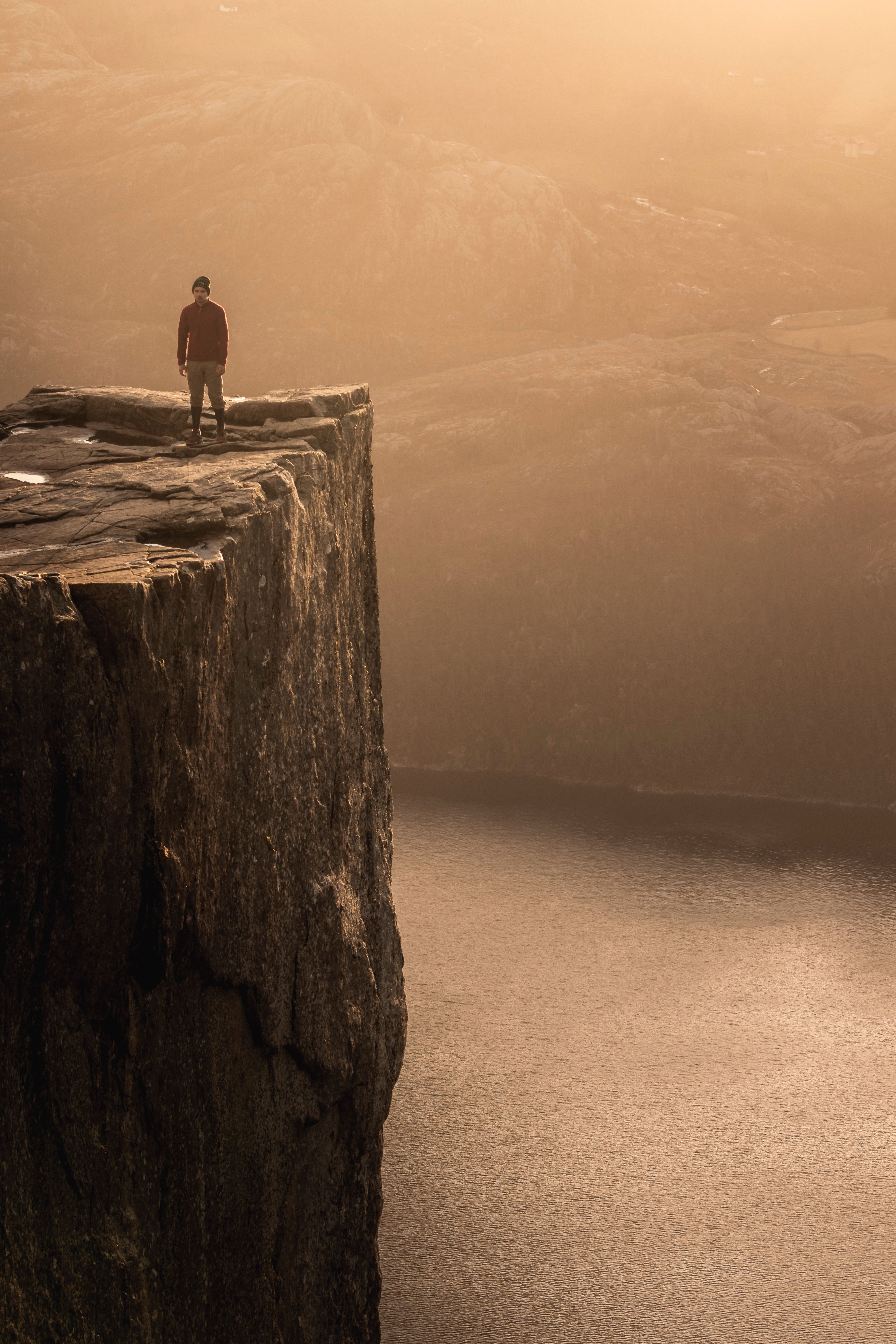 Hiker Standing on Cliff by River · Free Stock Photo