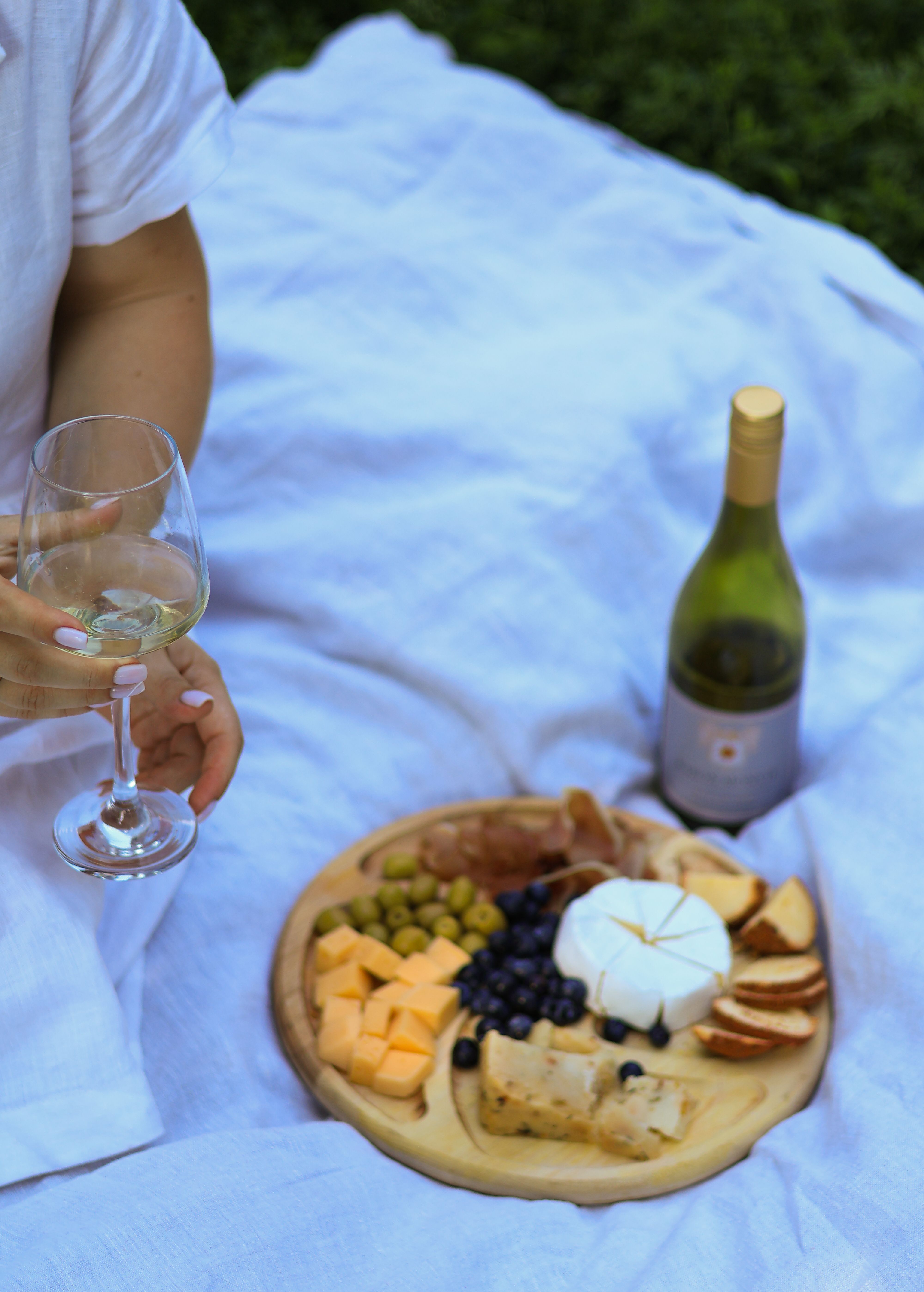 Cheeseboard and Wine Bottle on Blanket at Picnic · Free Stock Photo