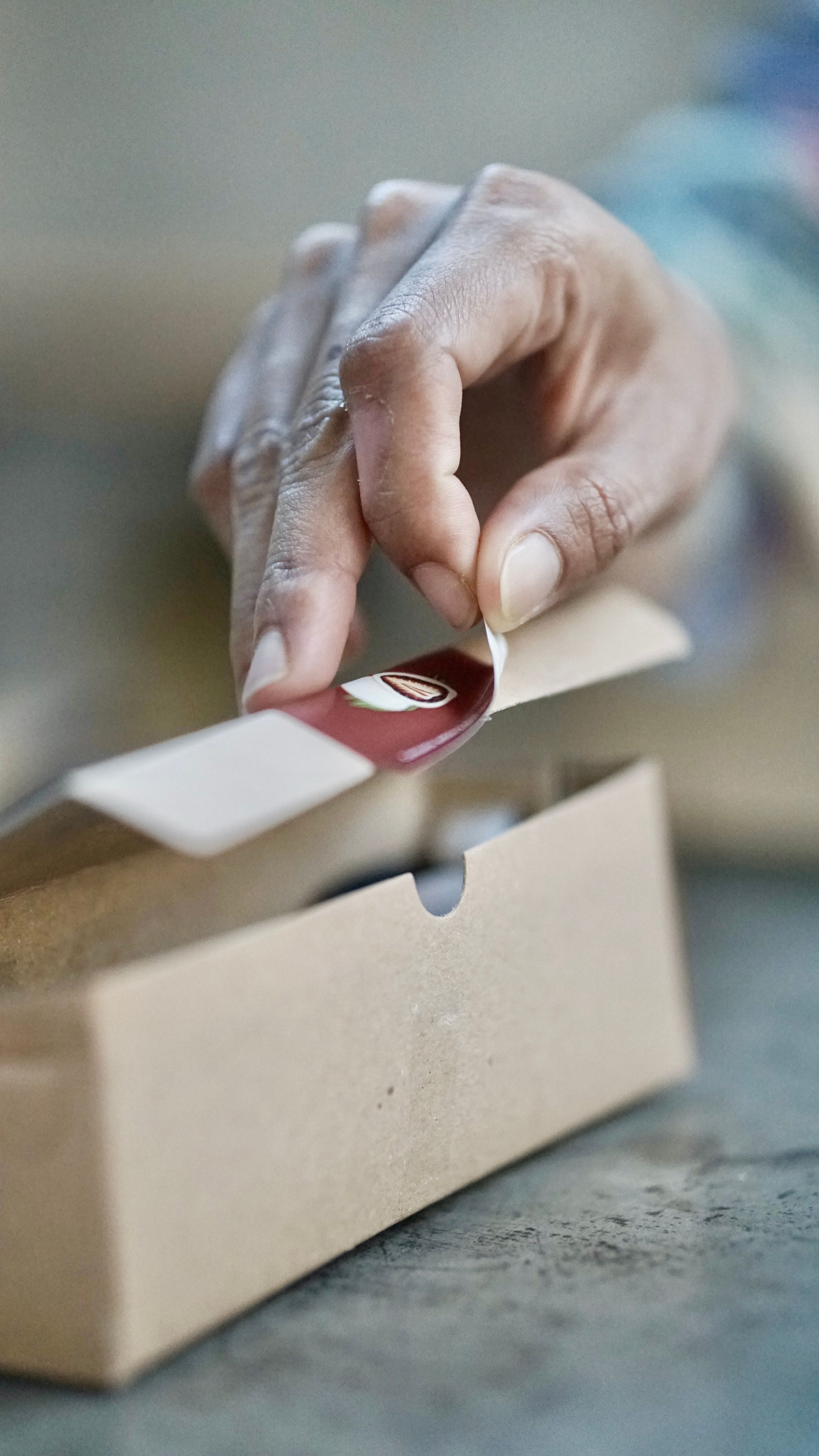 Hand Touching Sticker on Box · Free Stock Photo