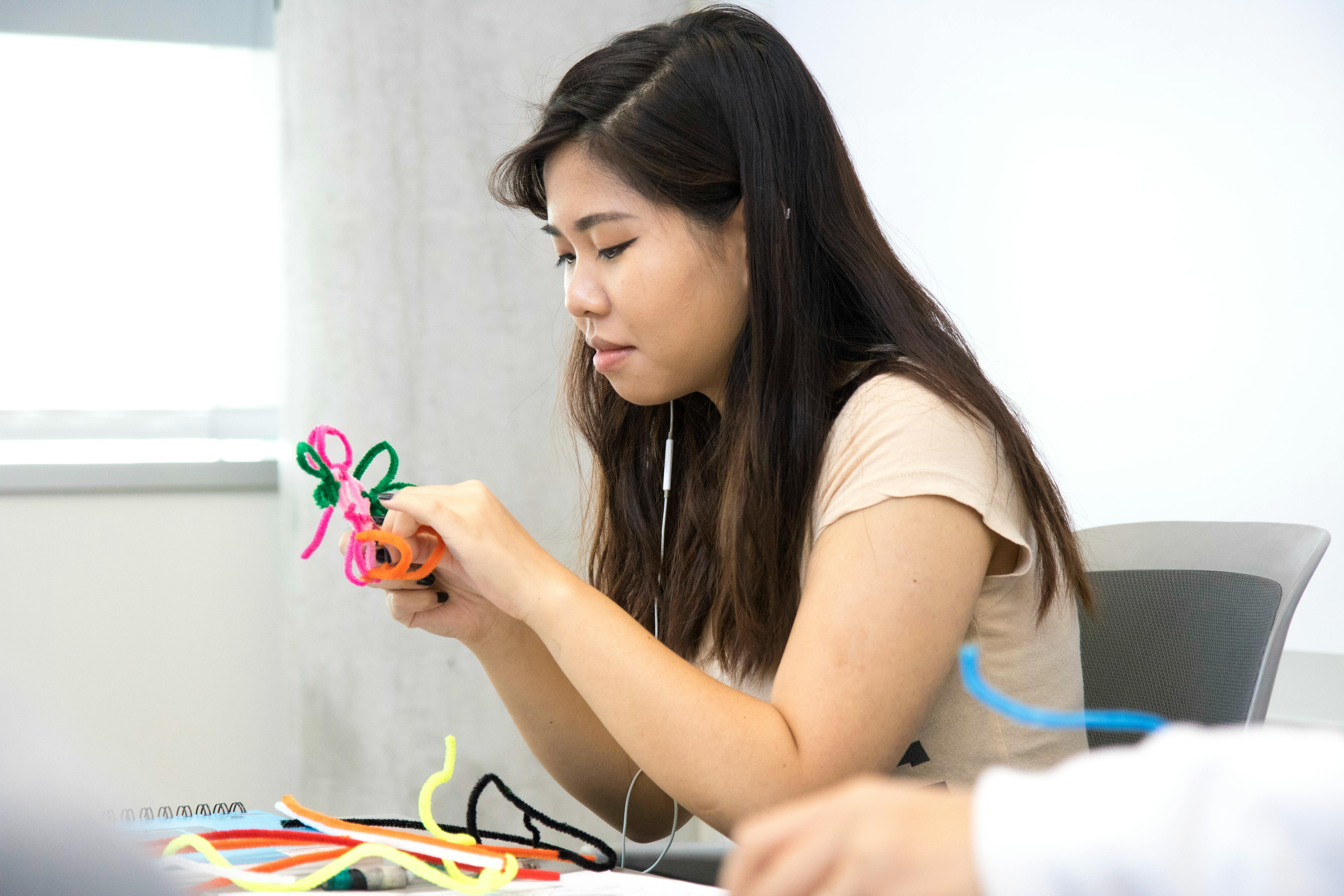 Woman Sitting with Colorful Strings · Free Stock Photo
