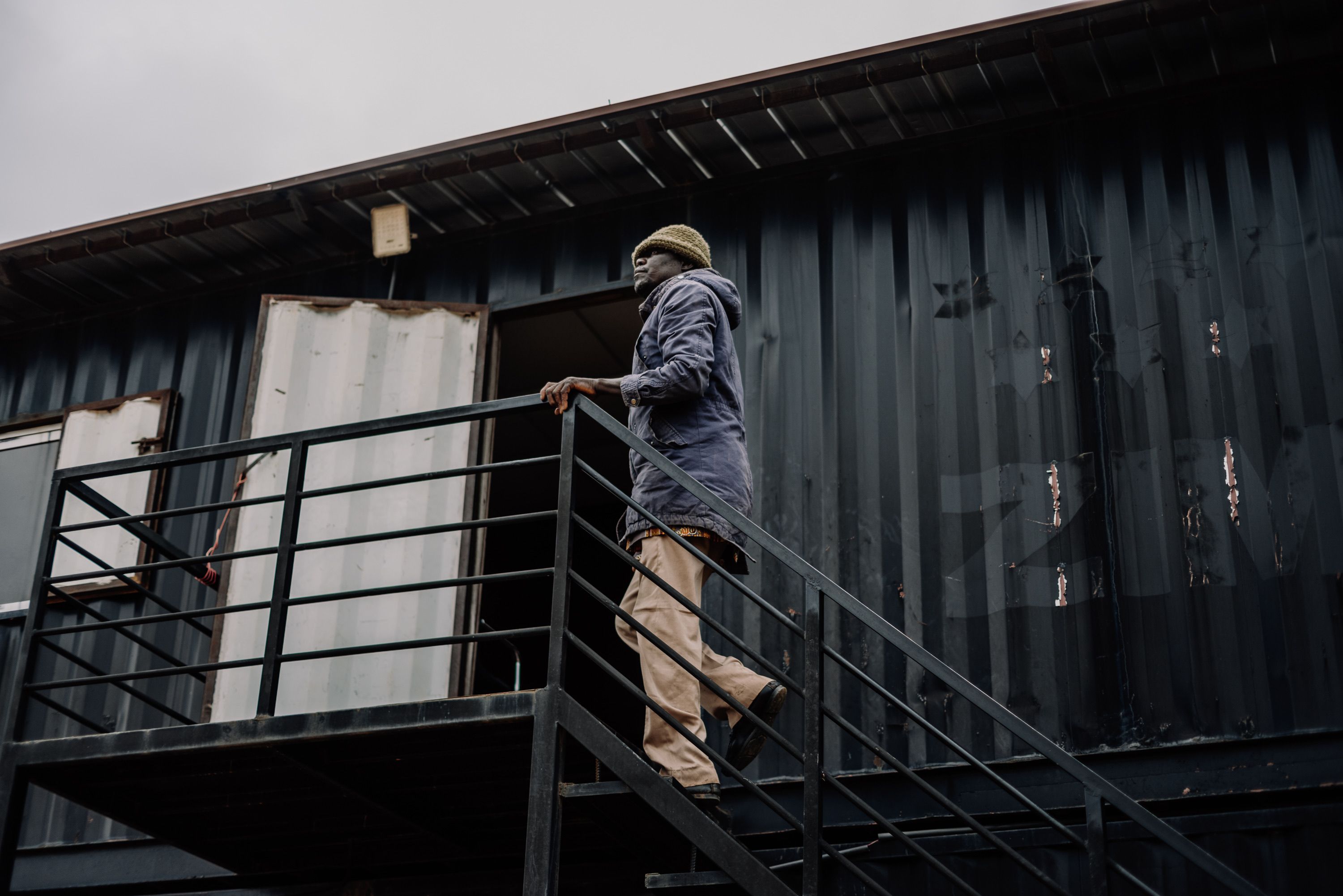 Man Walking up the Stairs into a Container Building · Free Stock Photo