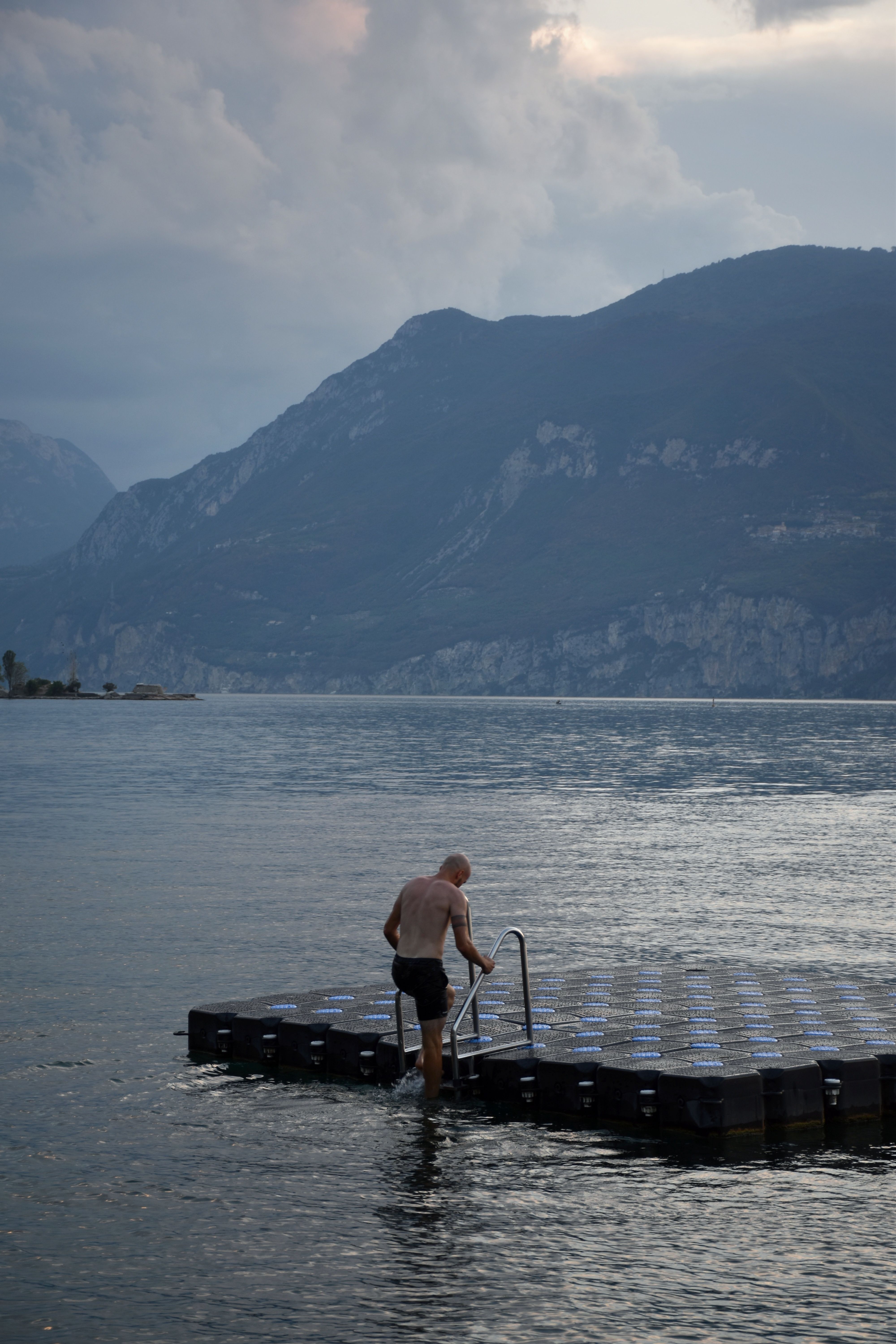 A man standing on a floating dock in the water · Free Stock Photo