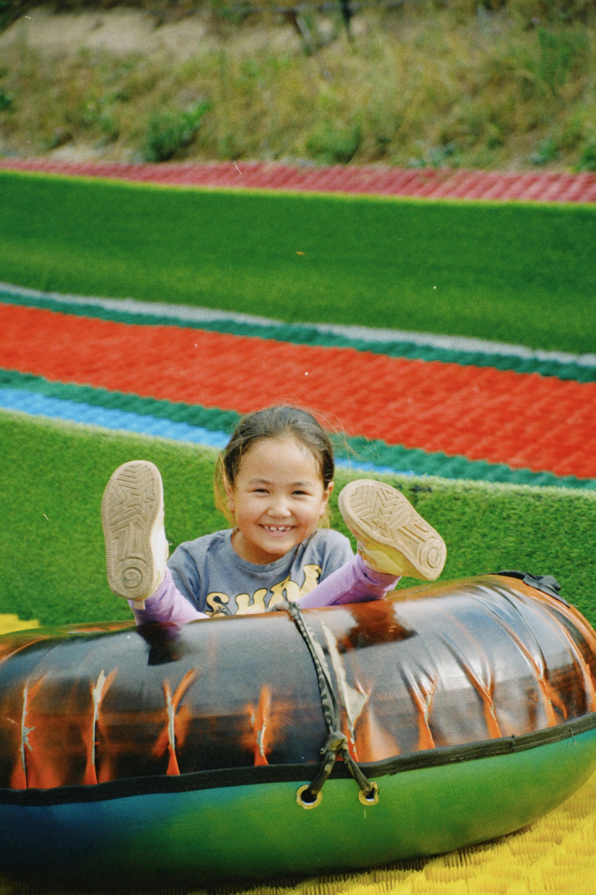 Happy Little Girl Sitting on Inflatable Wheel in Playground · Free ...