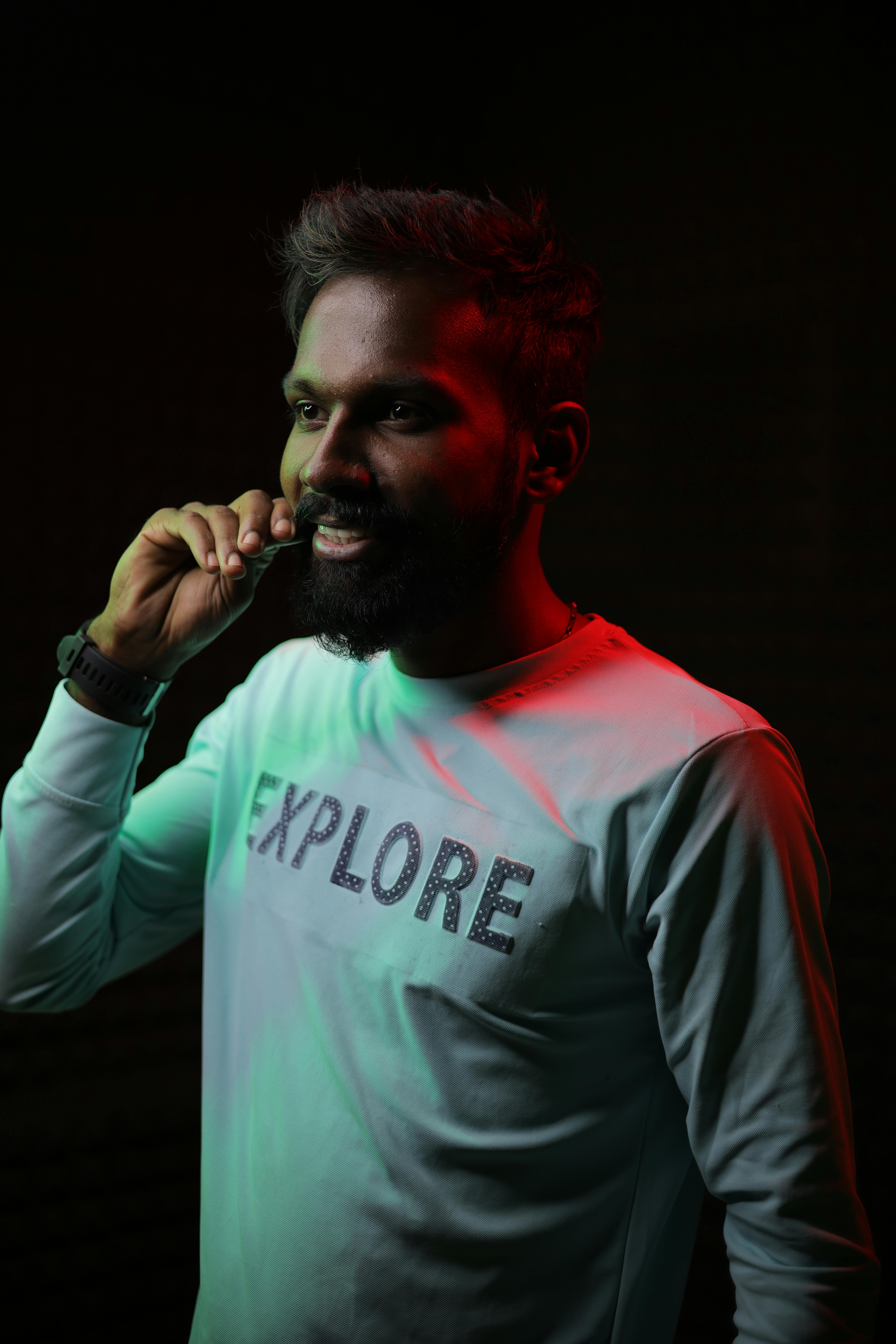Smiling Man Fixing Mustache in Studio · Free Stock Photo