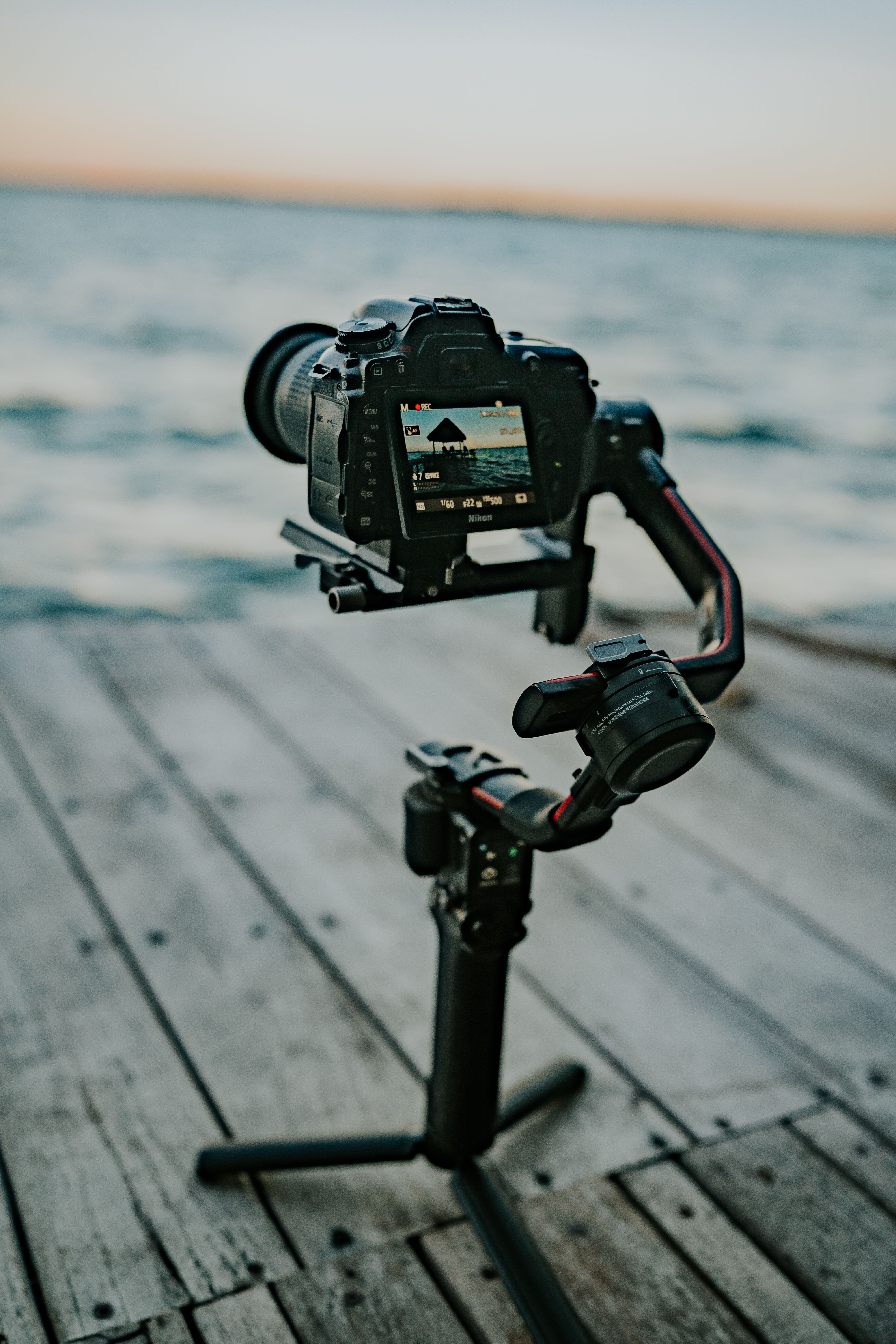 A camera on a tripod on a dock · Free Stock Photo