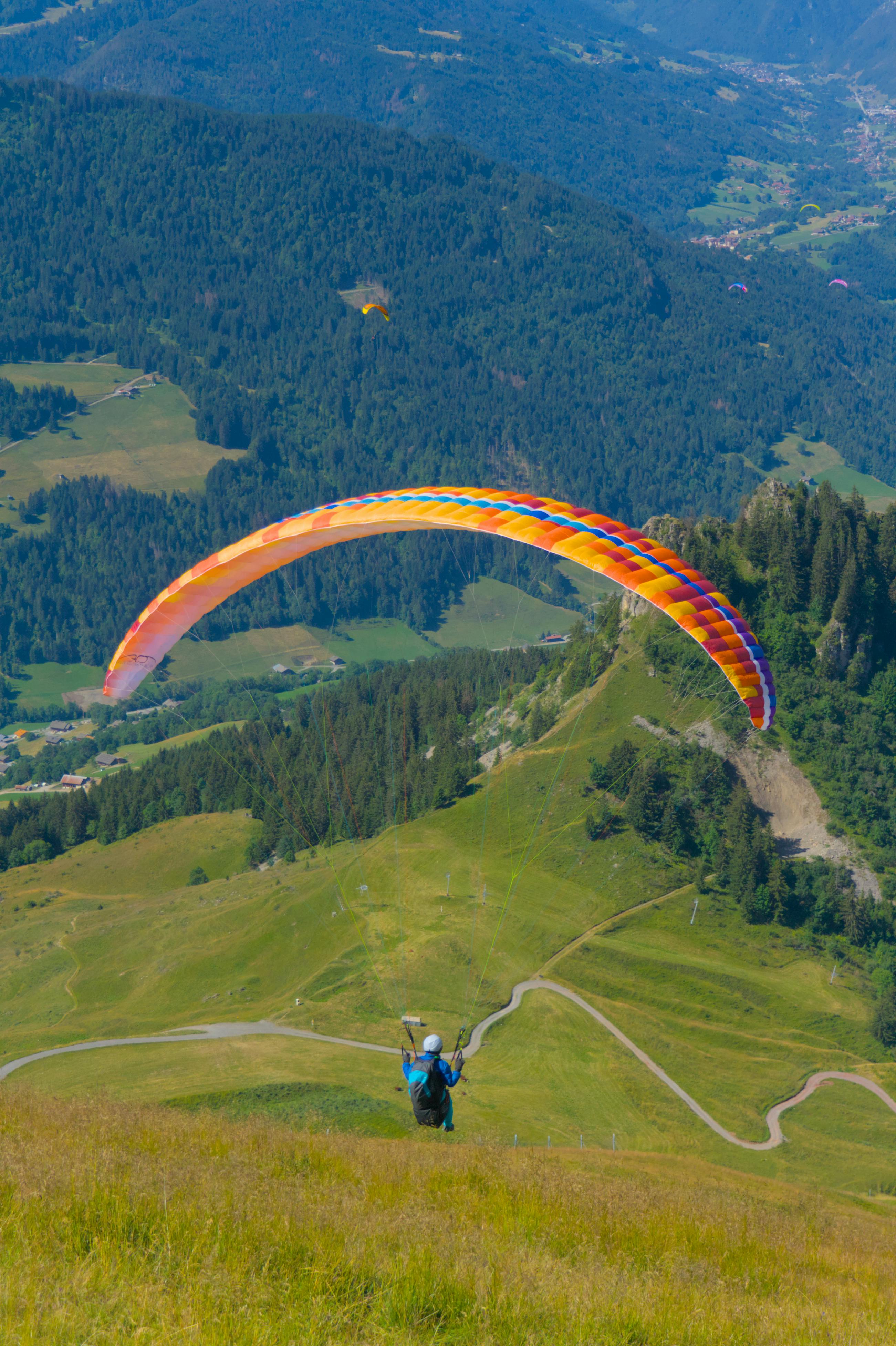A Person Paragliding in Mountains · Free Stock Photo