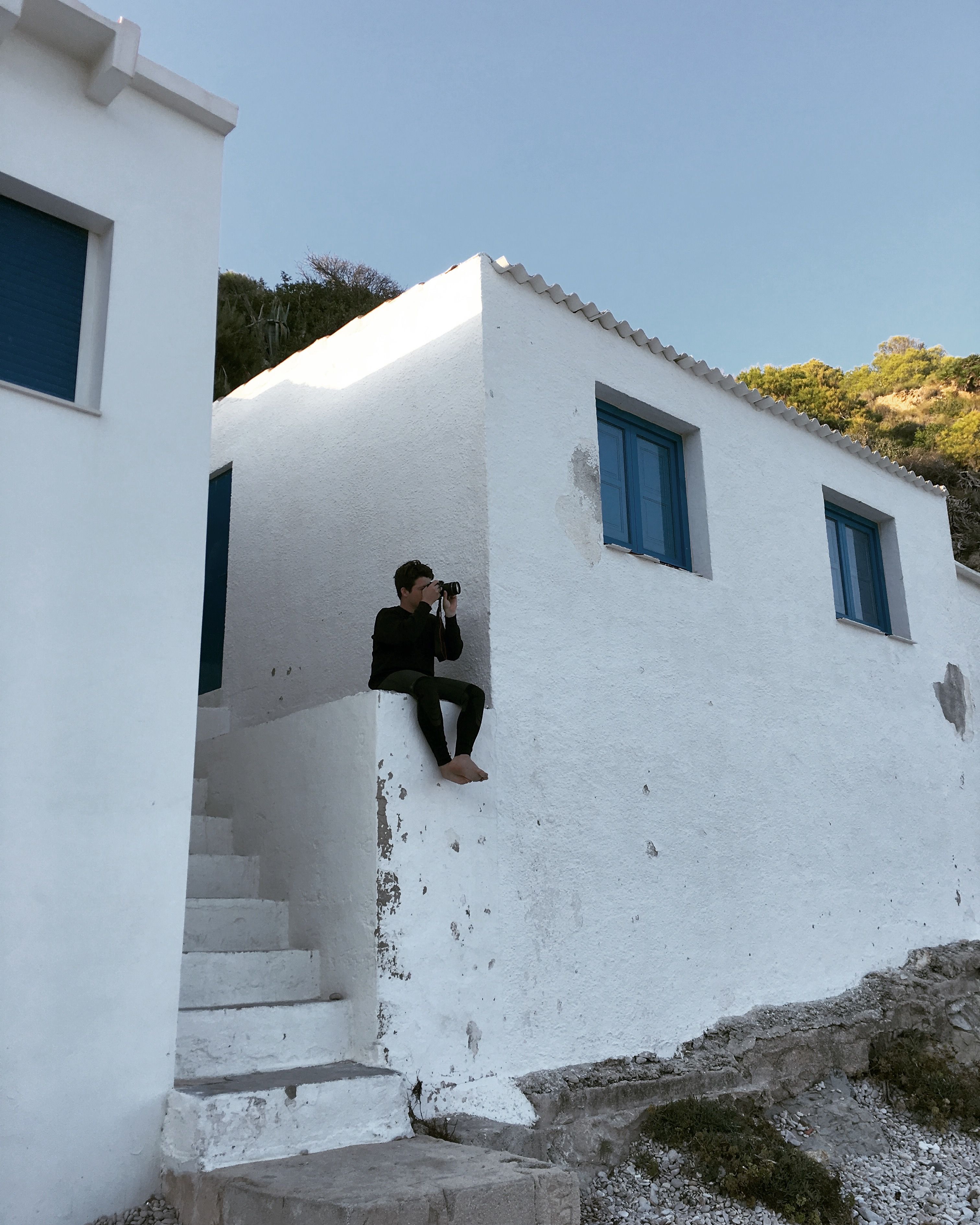 Man Sitting Near White Building · Free Stock Photo