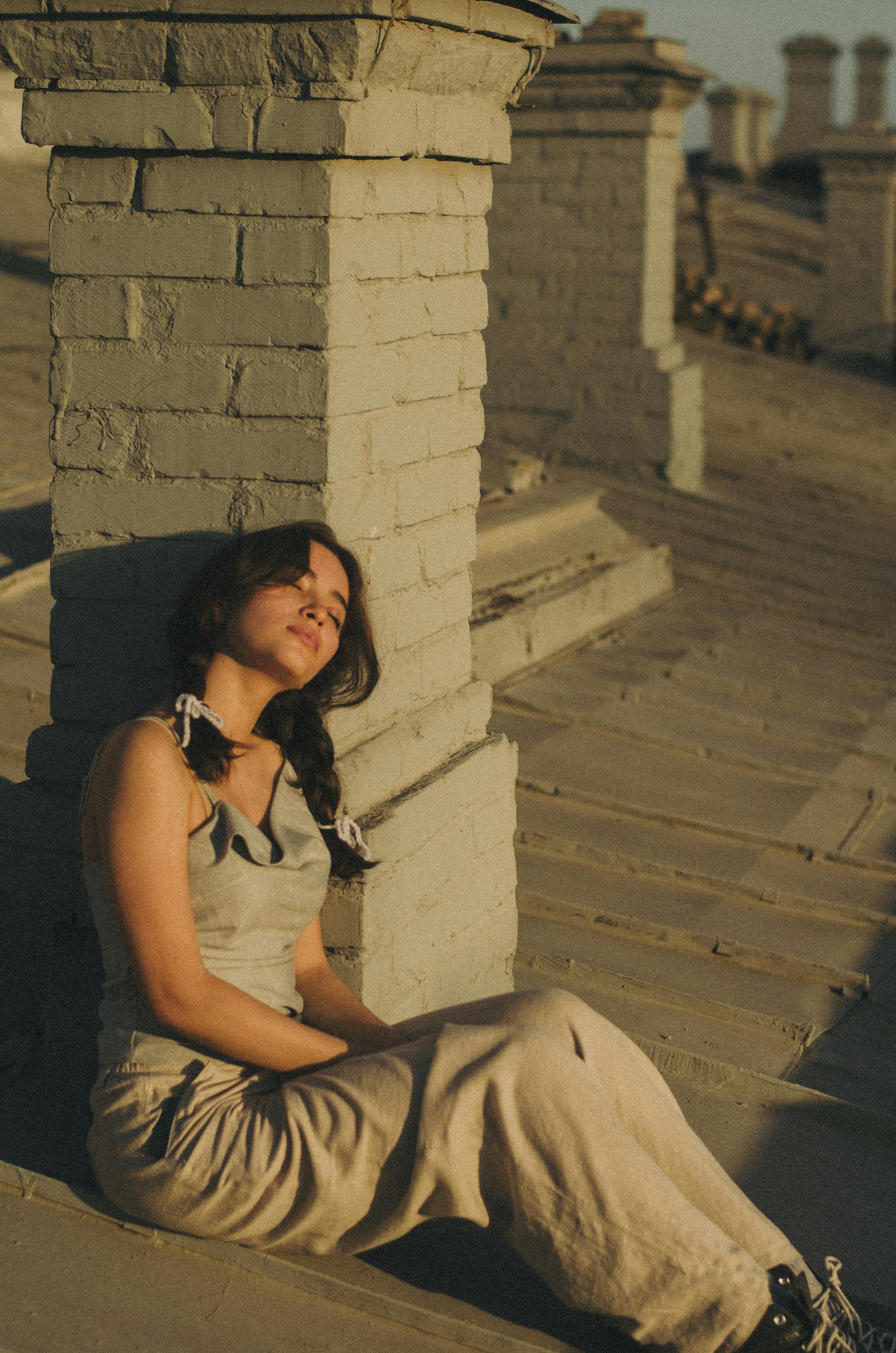 Woman Sitting on the Ground and Leaning on a Stone Column · Free Stock ...
