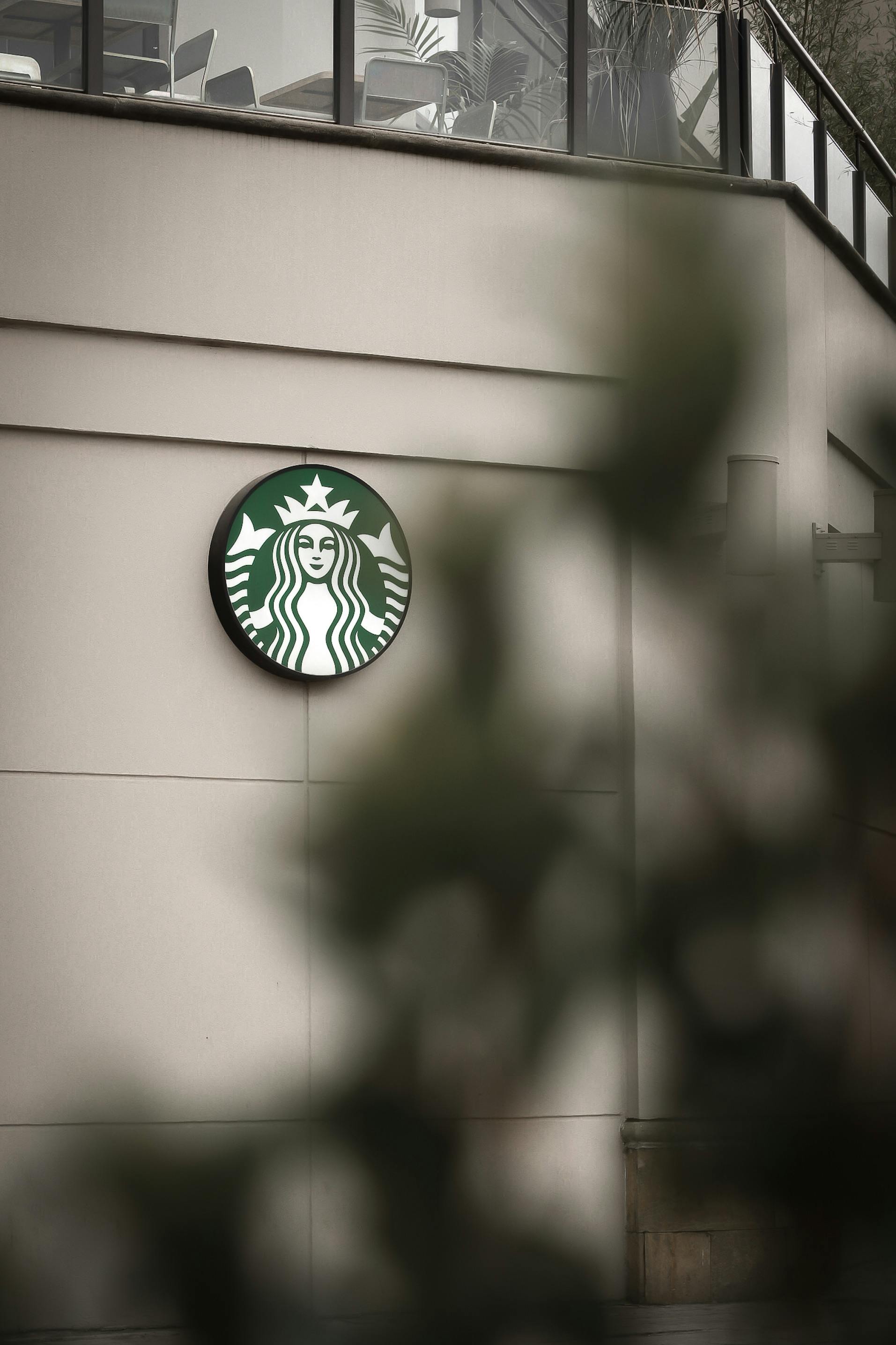 Roundel with Starbucks Logo on a Building Wall · Free Stock Photo