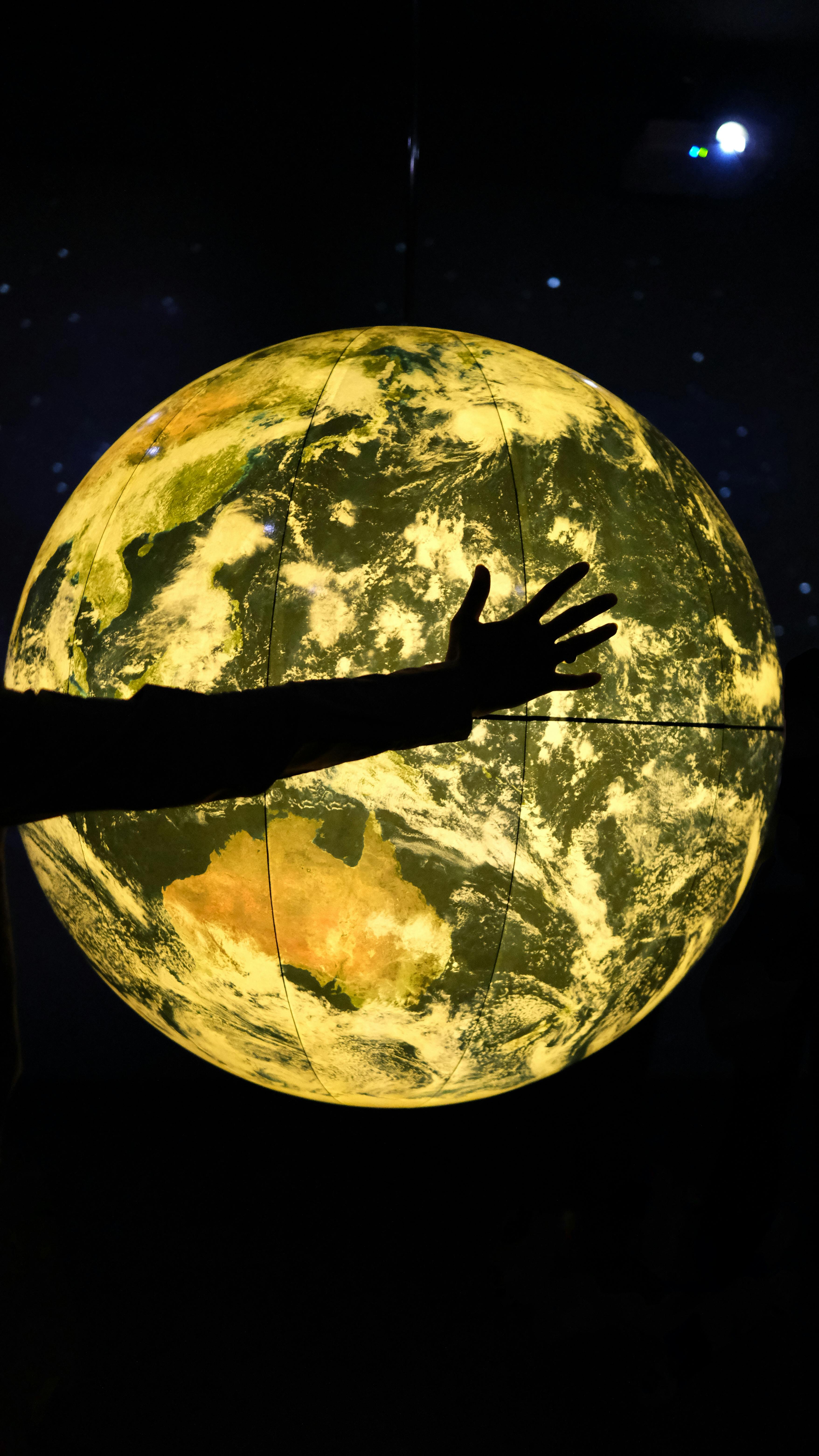 Hand over Globe Model · Free Stock Photo