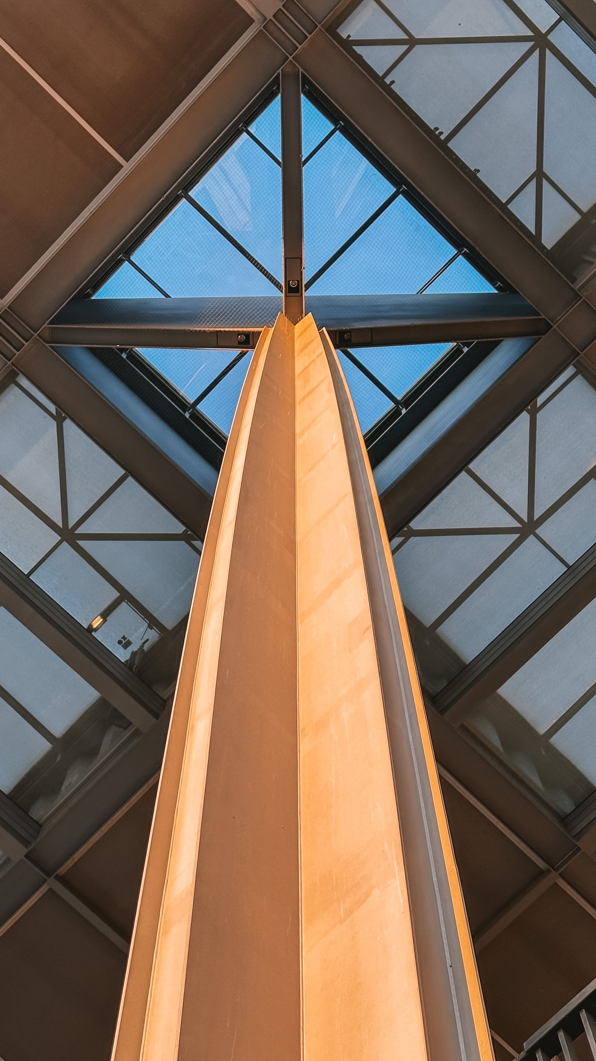 A tall wooden pole with a blue sky above it · Free Stock Photo