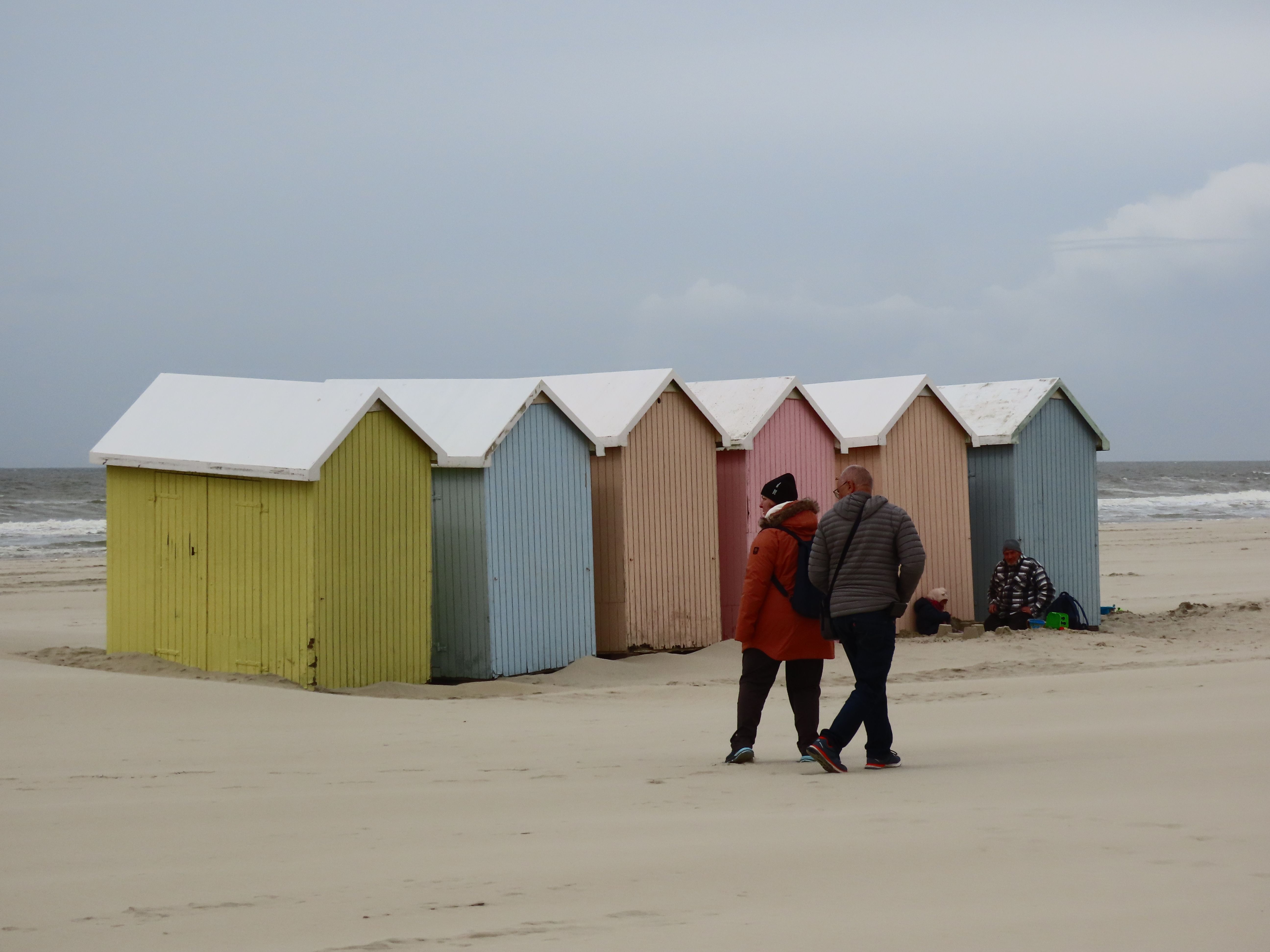People Walking near the Beach Huts · Free Stock Photo