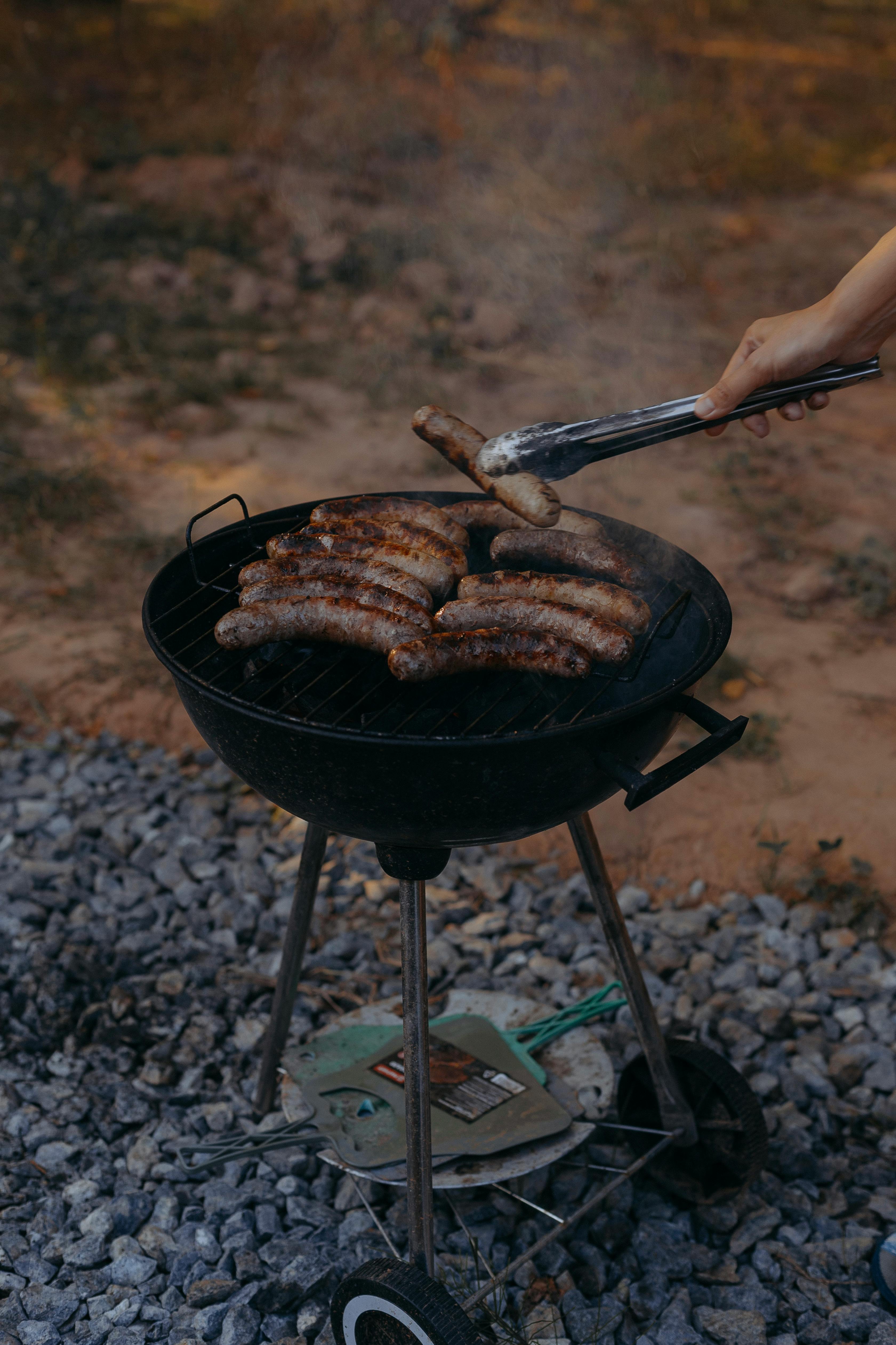 Person Grilling Sausage and Meat · Free Stock Photo