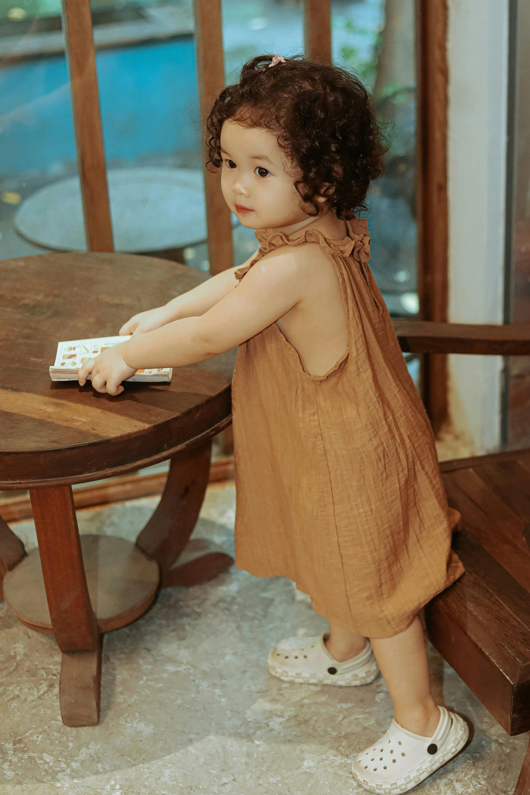 Little Girl Putting the Book on the Table · Free Stock Photo