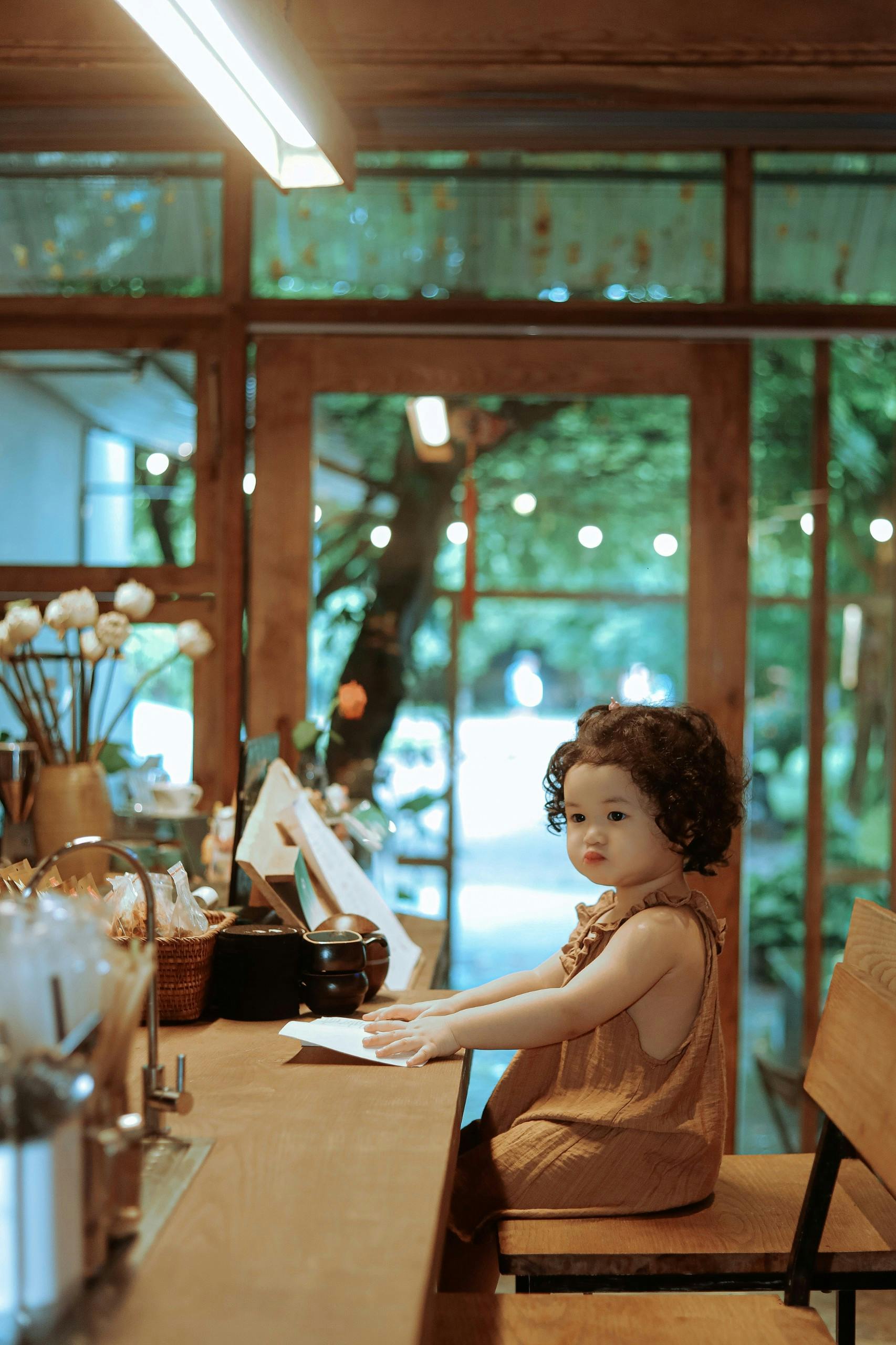 Little Girl Sitting at Bar Counter in Restaurant · Free Stock Photo