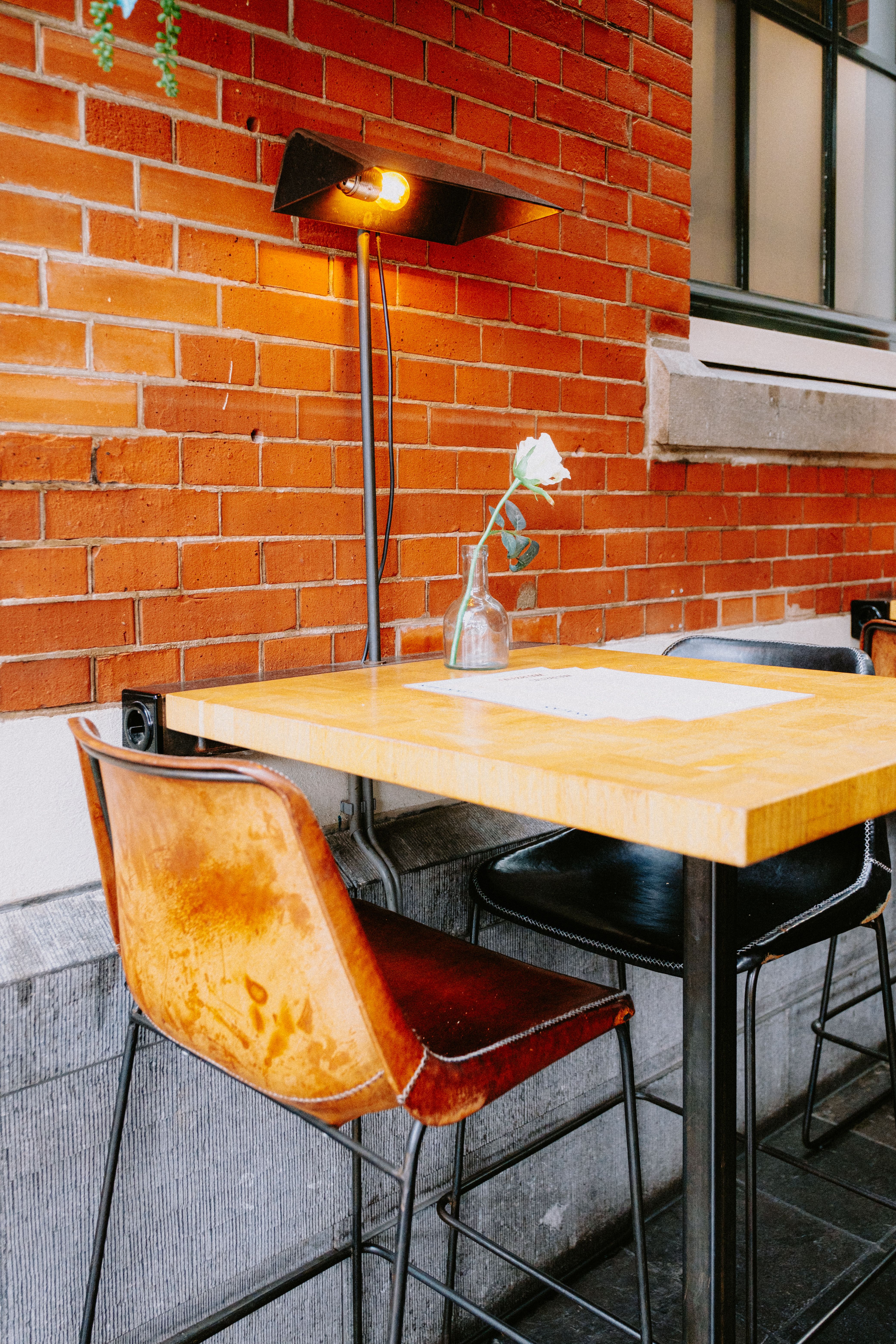 Table and Seats by Brick Wall · Free Stock Photo