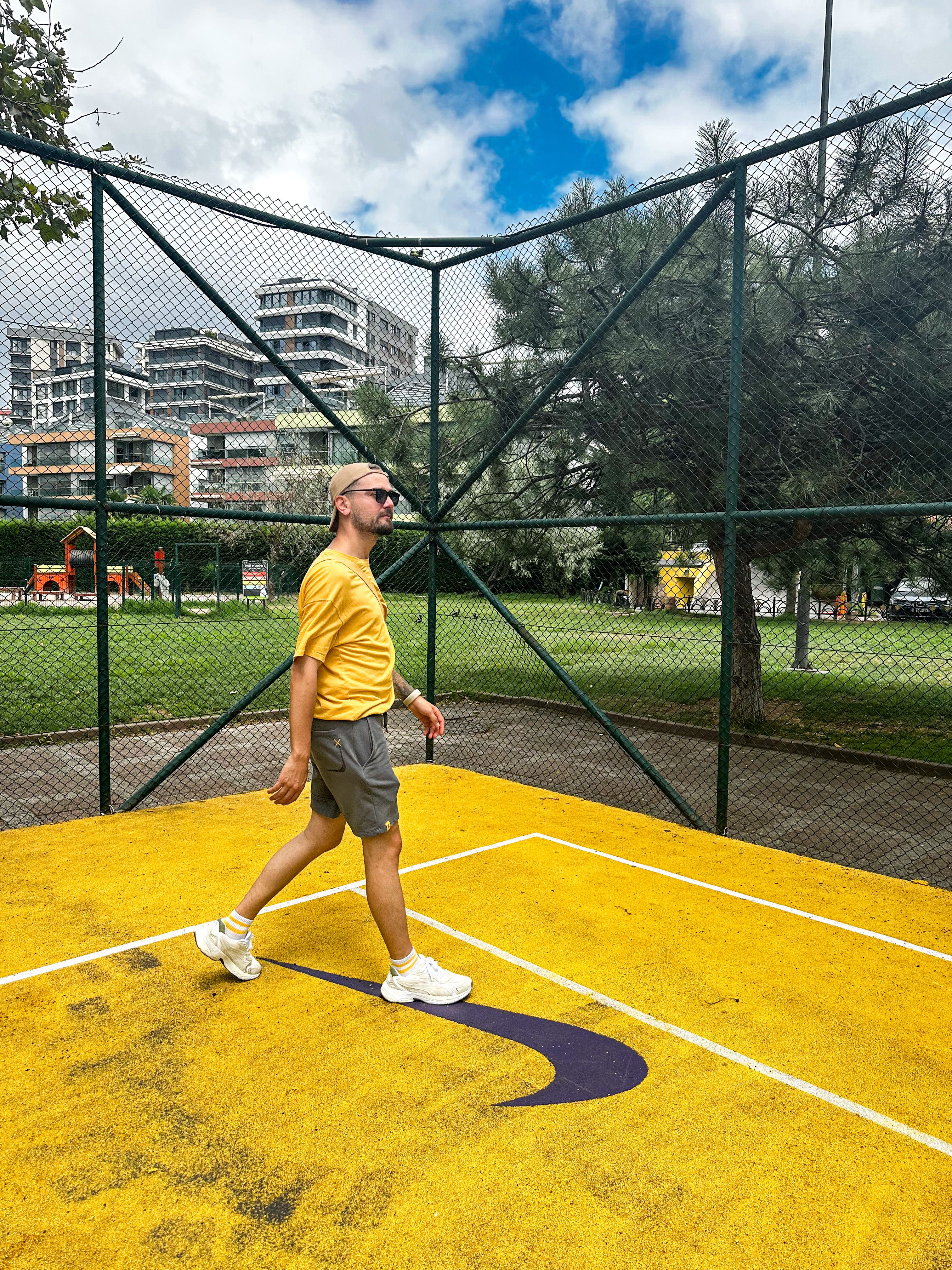 Man in Yellow T-shirt Walking on Yellow Tennis Court · Free Stock Photo
