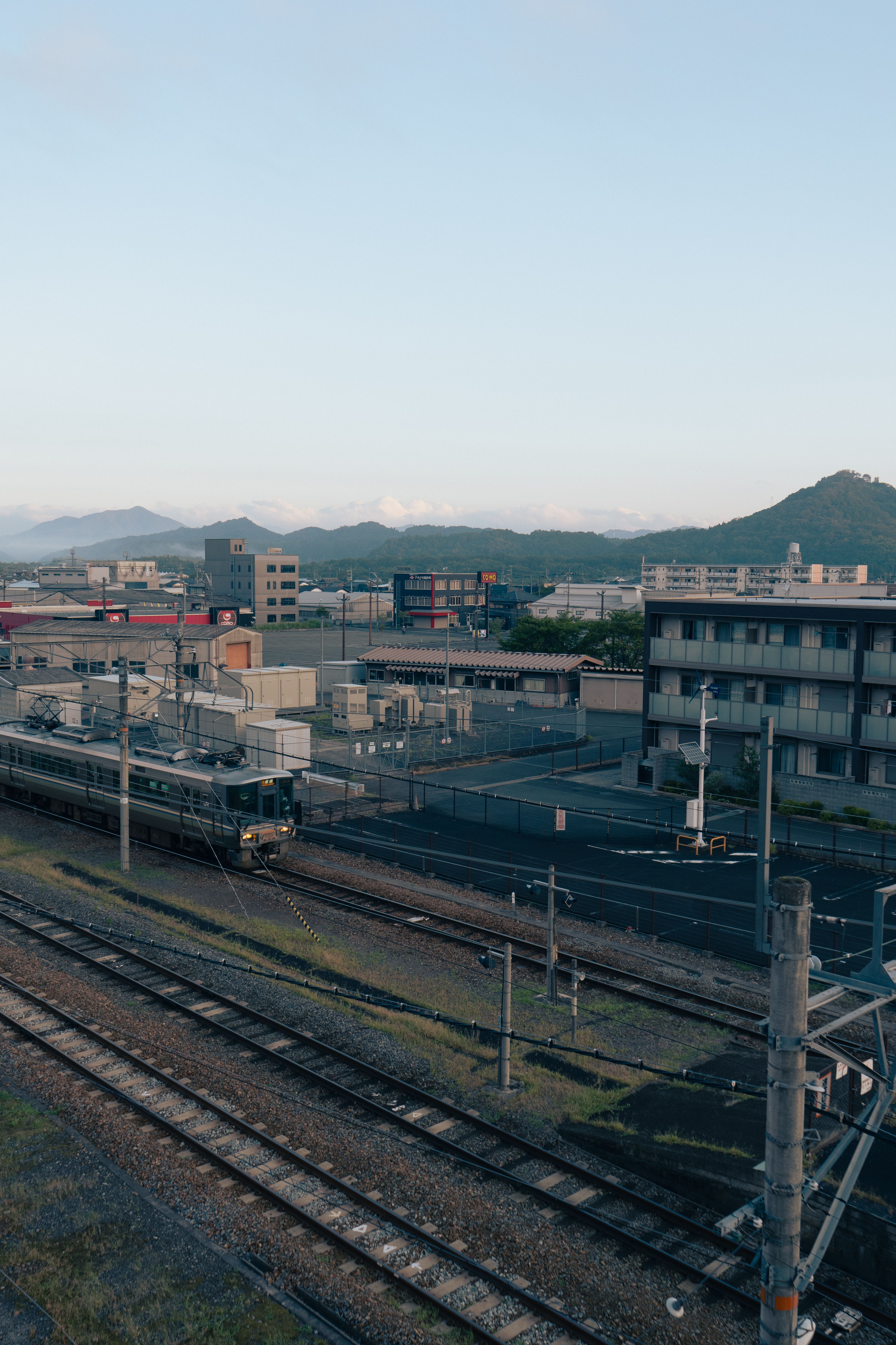 Aerial View of a Train Approaching the Station in a City near Mountains ...