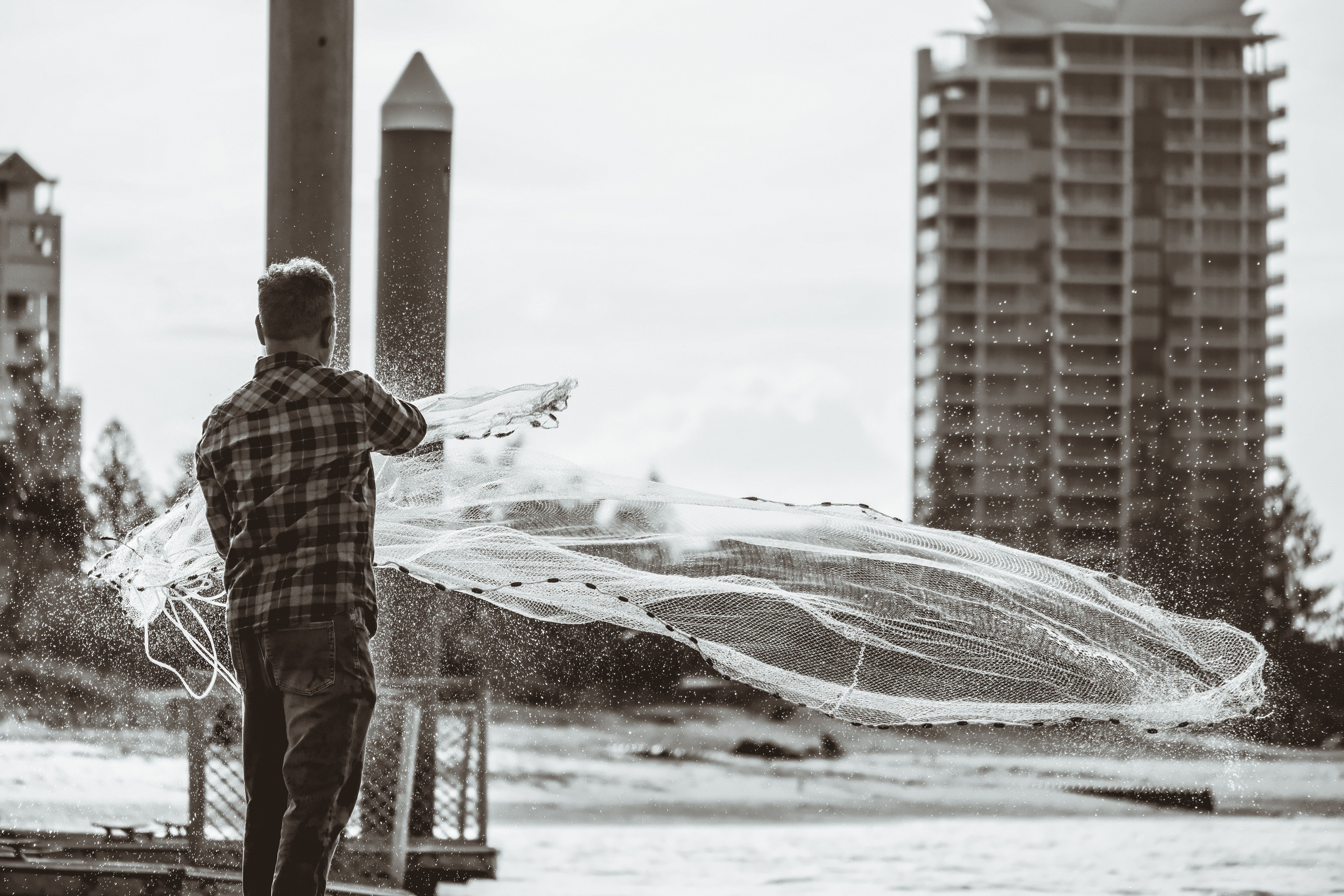 Fisherman Throwing the Net from the Pier · Free Stock Photo