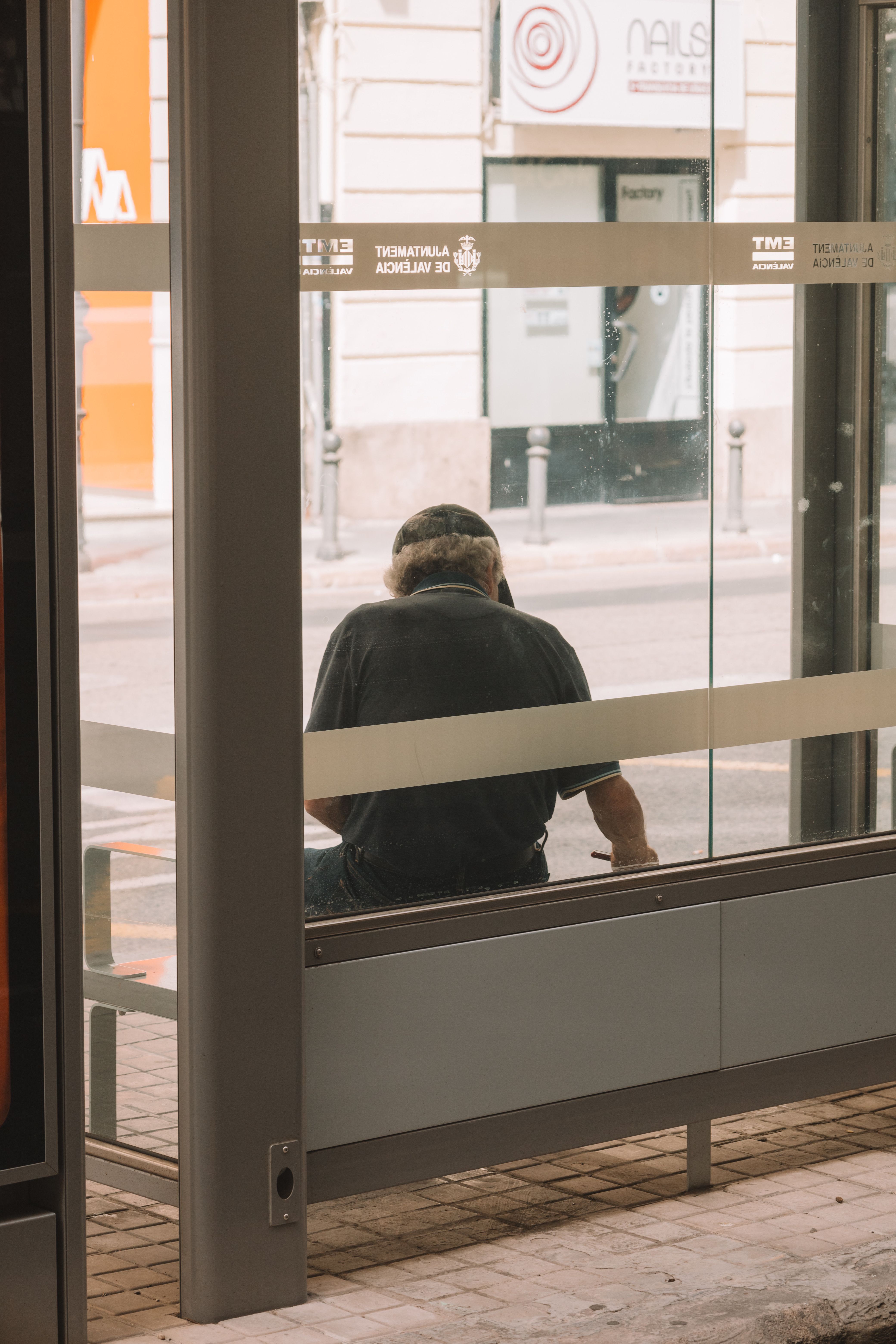 Man Sitting on Bus Stop · Free Stock Photo