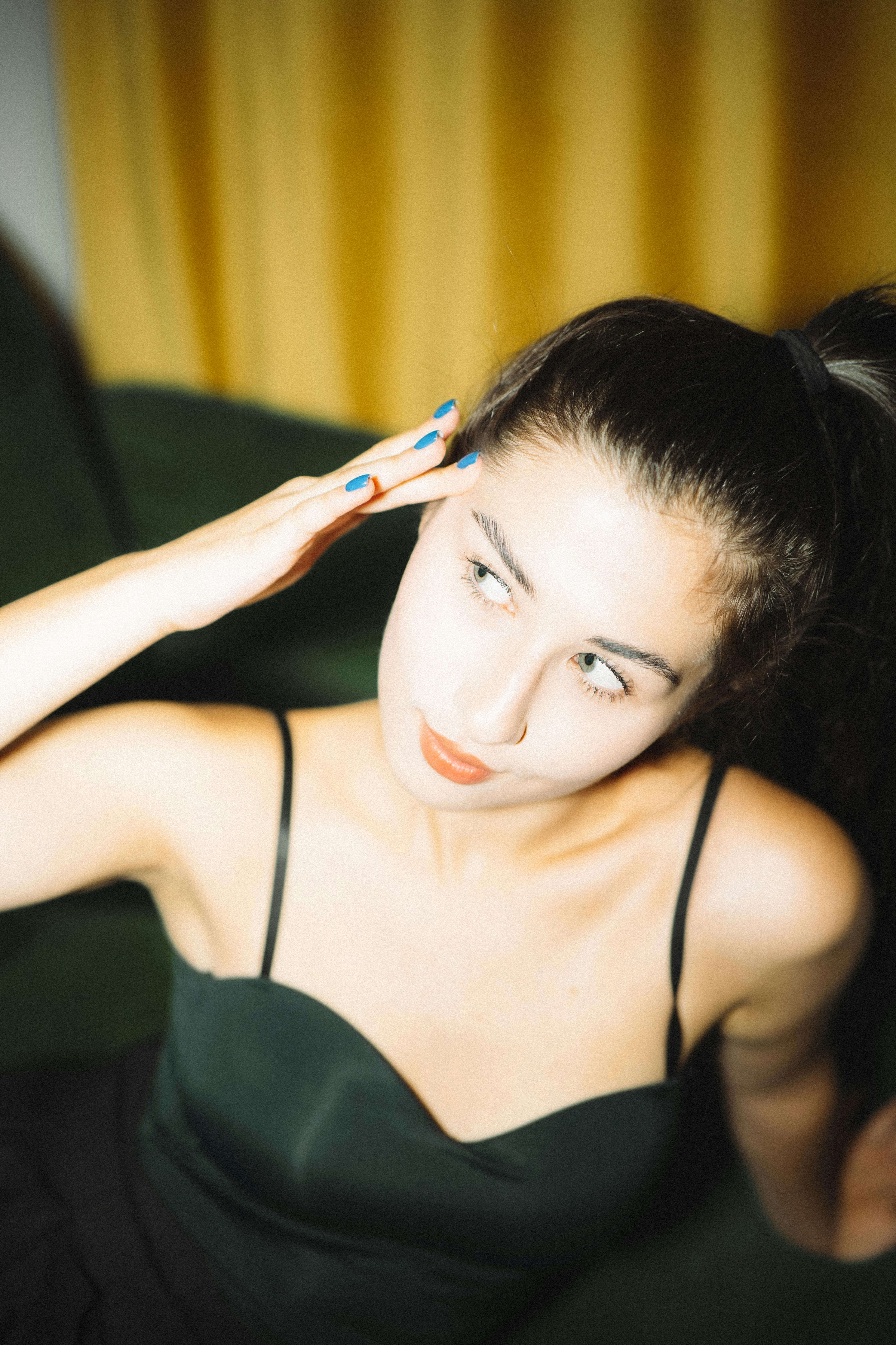 Young Woman Touching Her Temple · Free Stock Photo