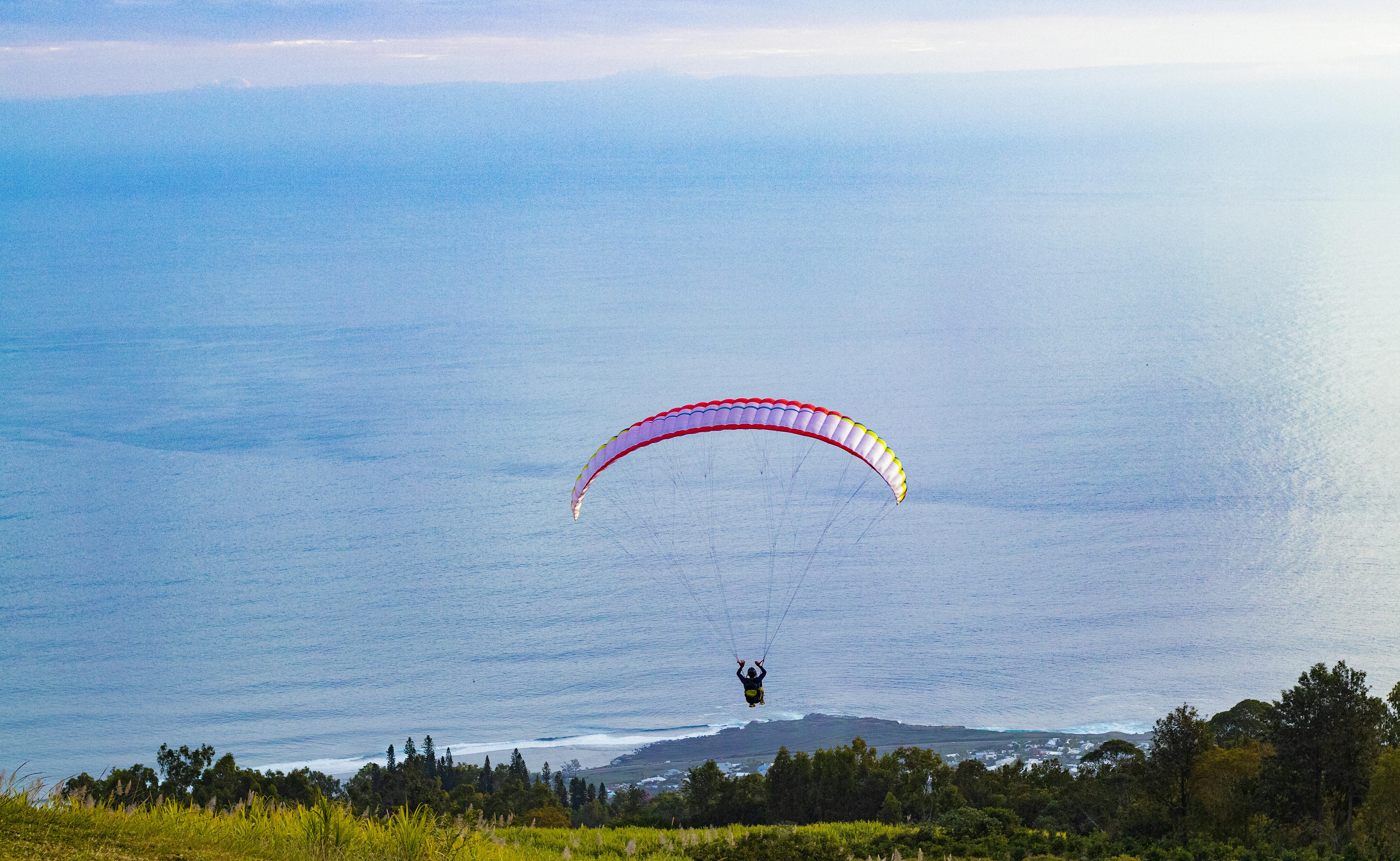 Person with Parachute Falling Near Seashore · Free Stock Photo
