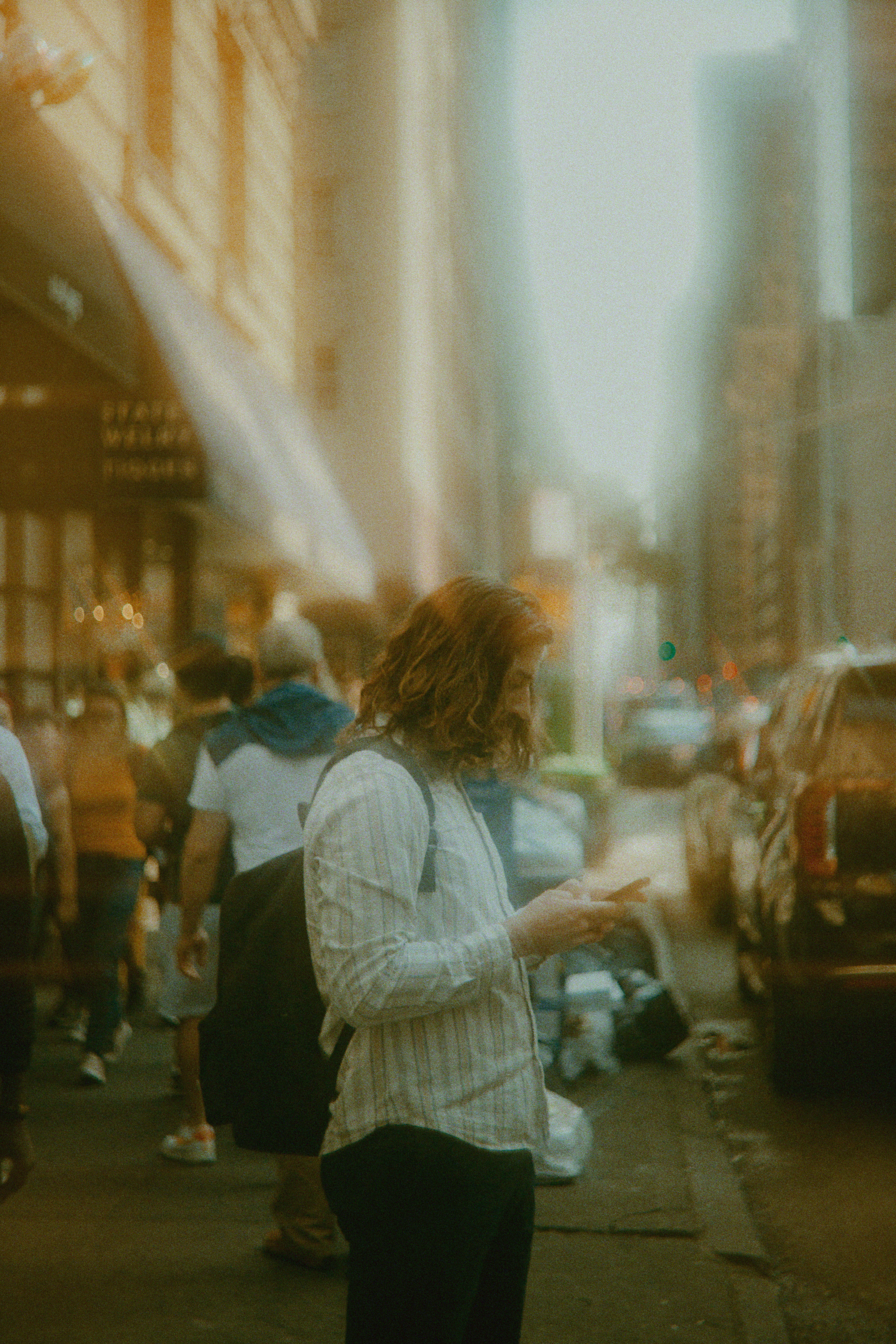 A Man Standing on the Sidewalk in a Busy Downtown · Free Stock Photo