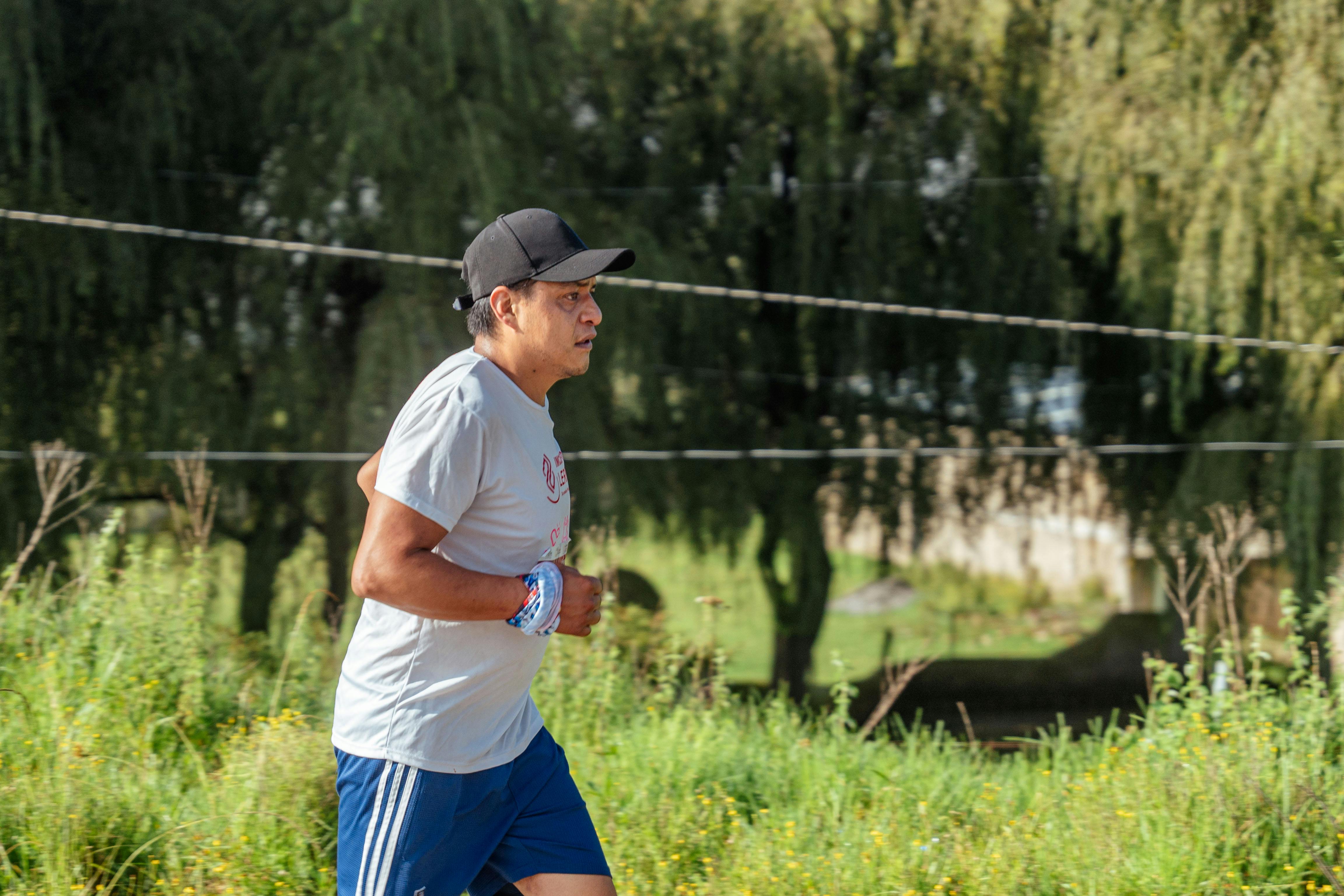 Person Running Near Street Between Tall Trees · Free Stock Photo