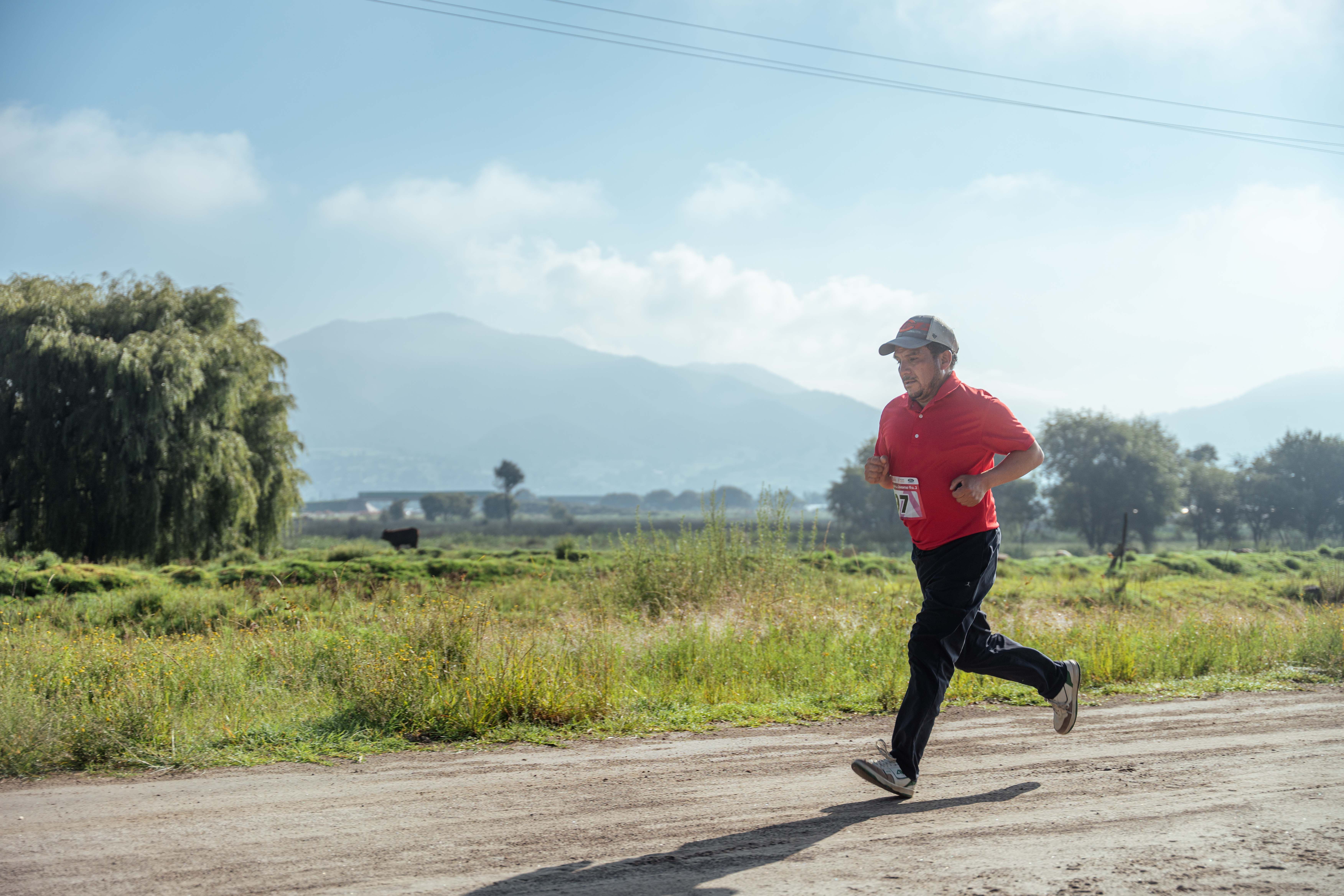Man Running in Race on Dirt Road · Free Stock Photo