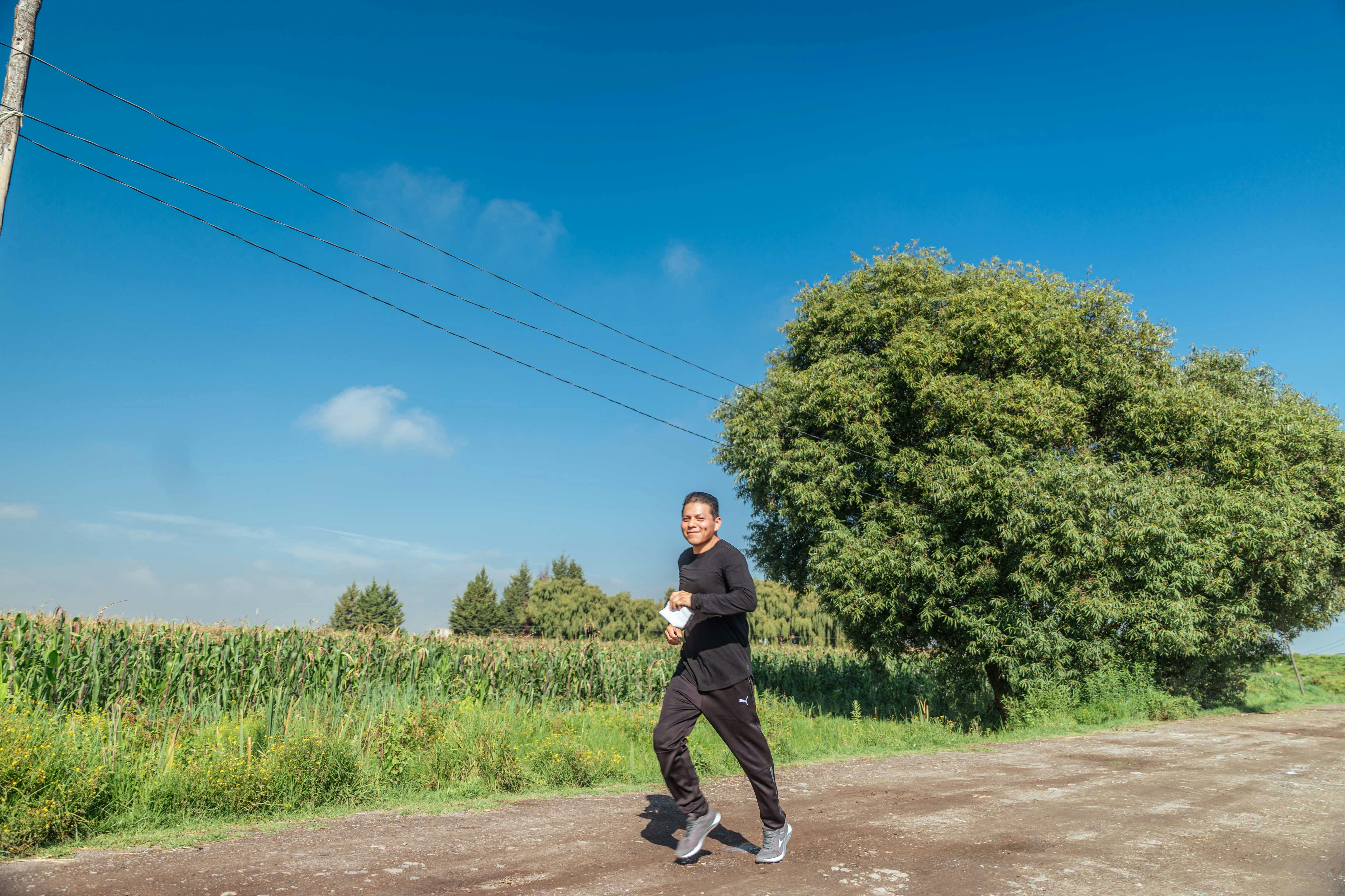 Man Running on Dirt Road near Field · Free Stock Photo