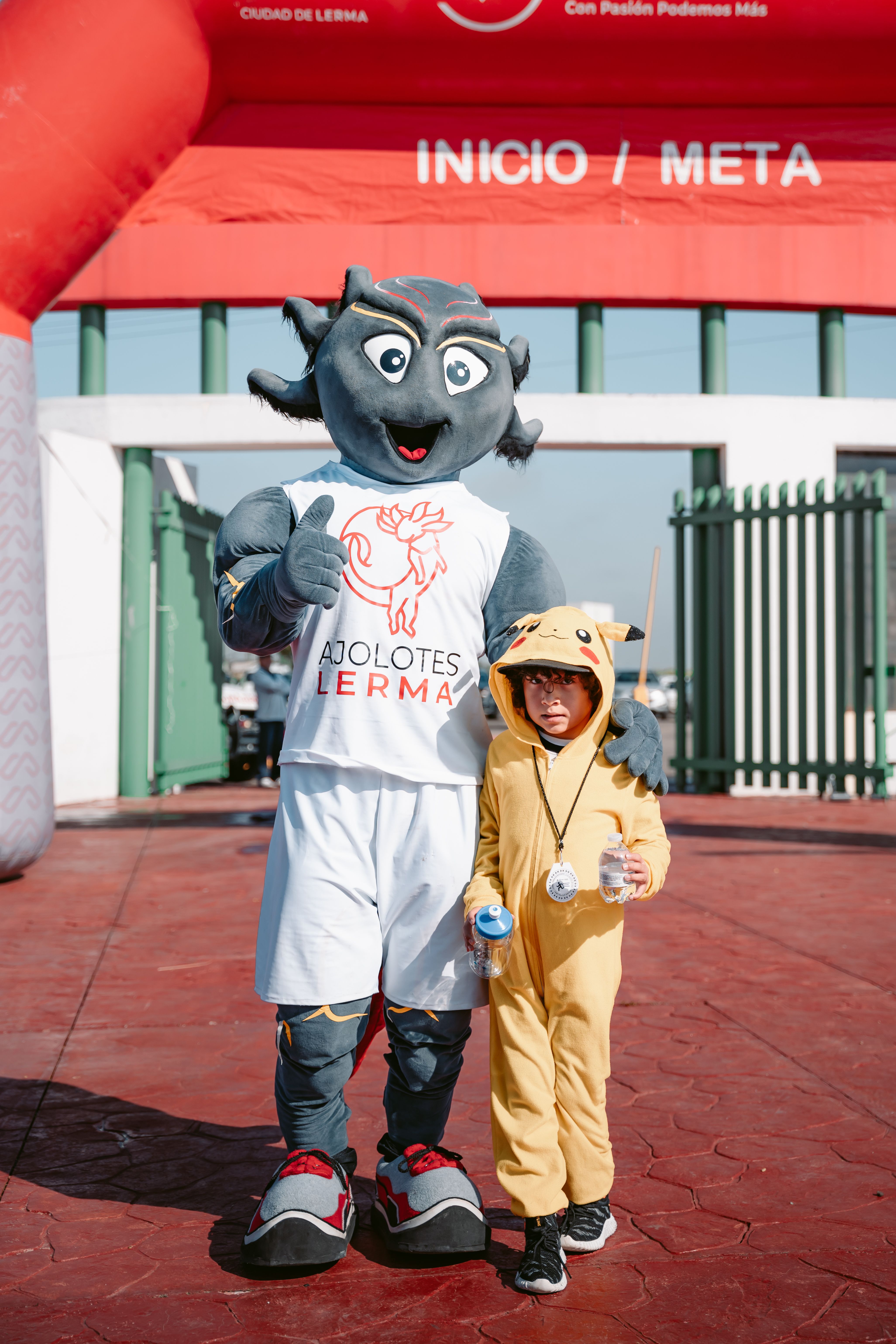 Young Runner Standing with Mascot · Free Stock Photo