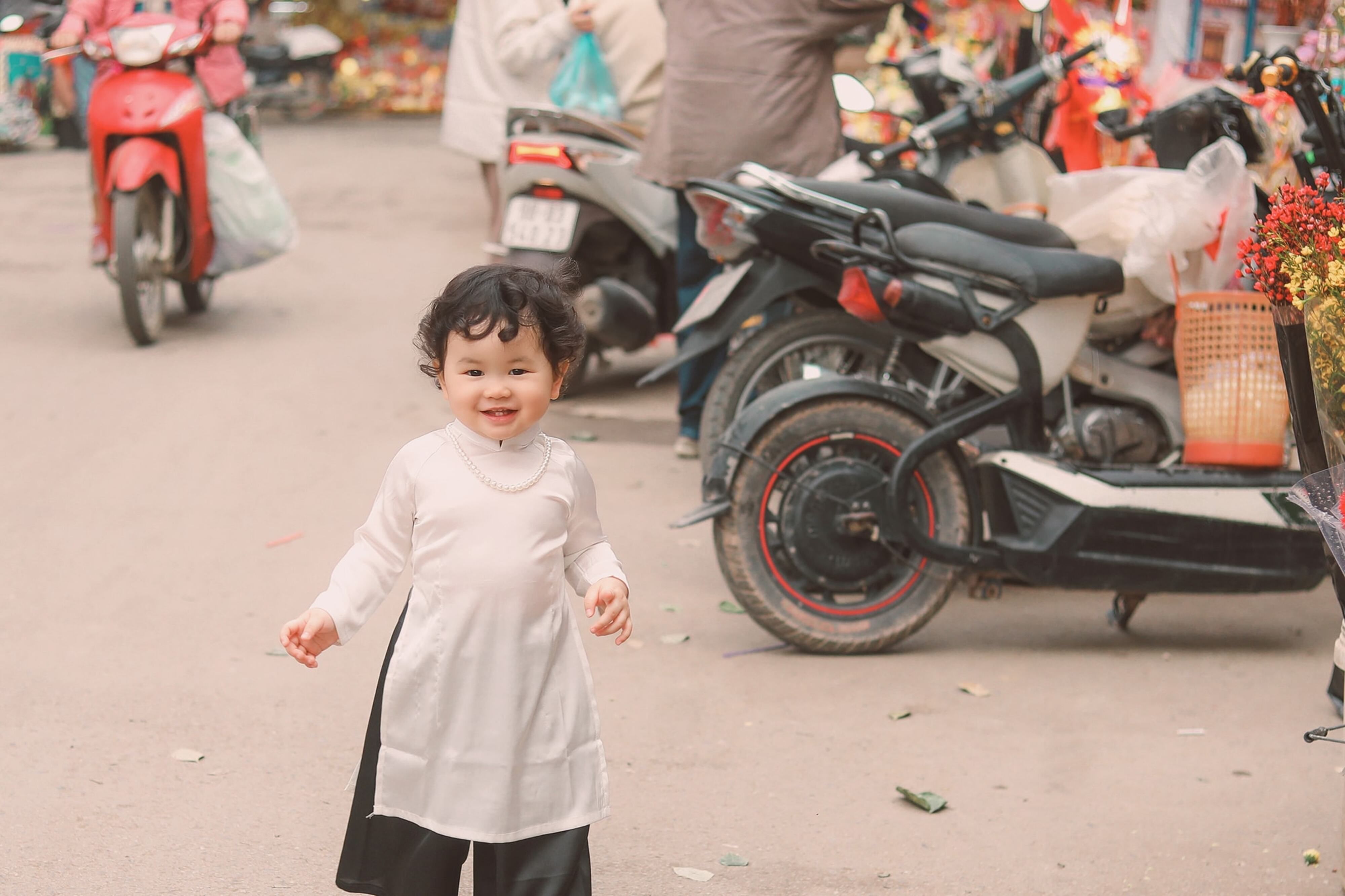 Smiling Child in White Tunic Standing on Street · Free Stock Photo