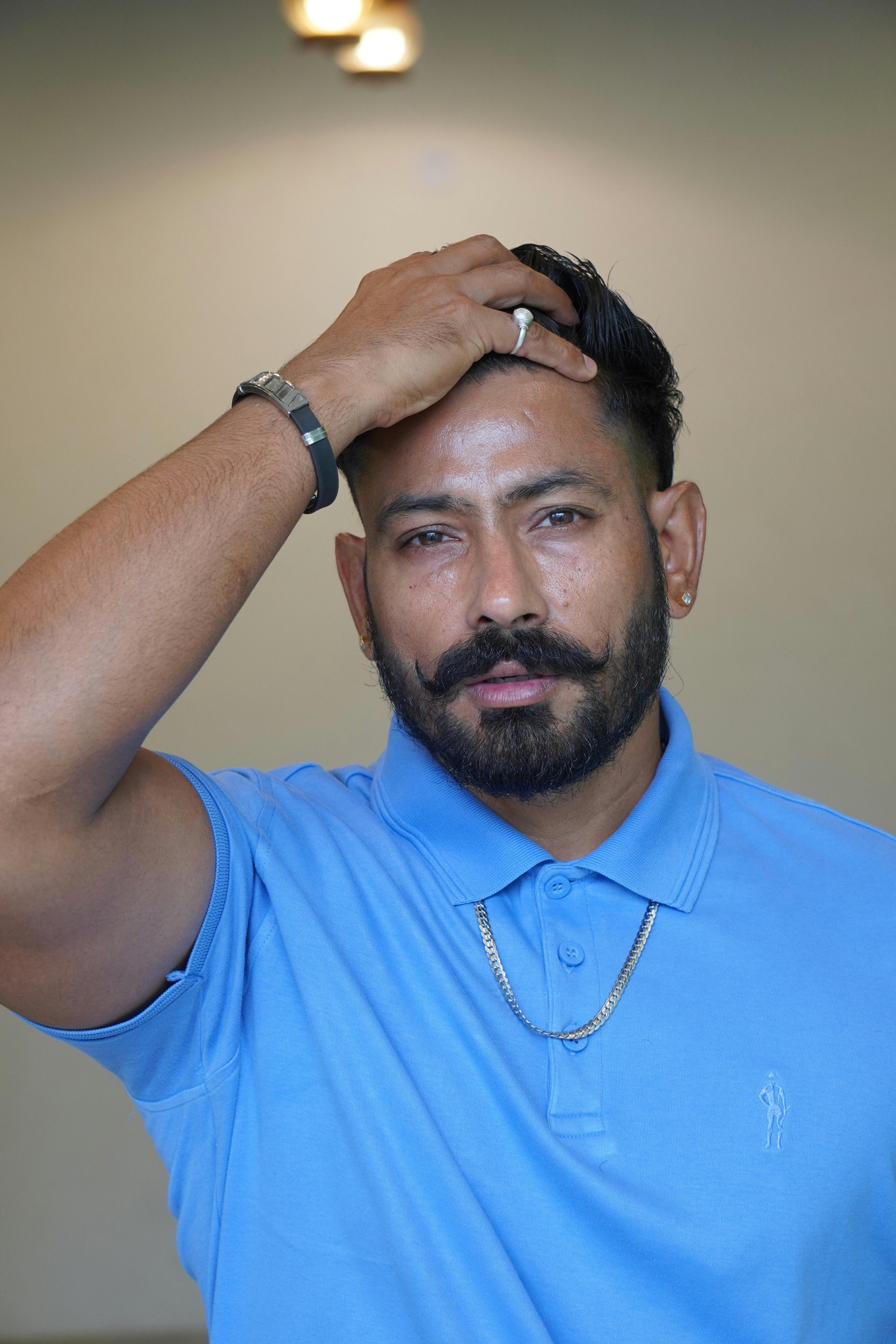 Man with Beard and Waxed Curled Mustache Fixing his Hair · Free Stock Photo