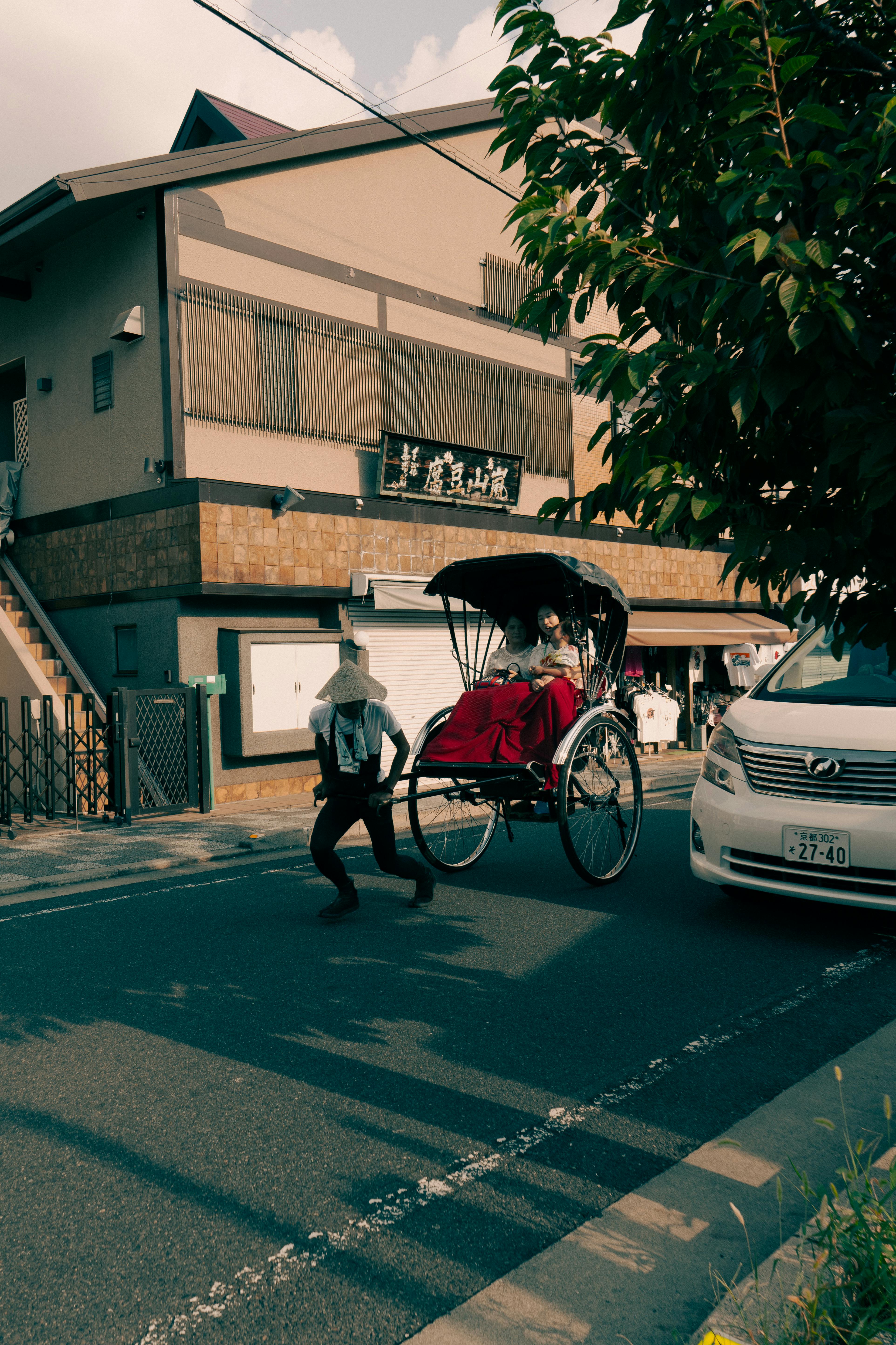 Man in Conical Hat Towing Rickshaw on Street in Town in Japan · Free ...