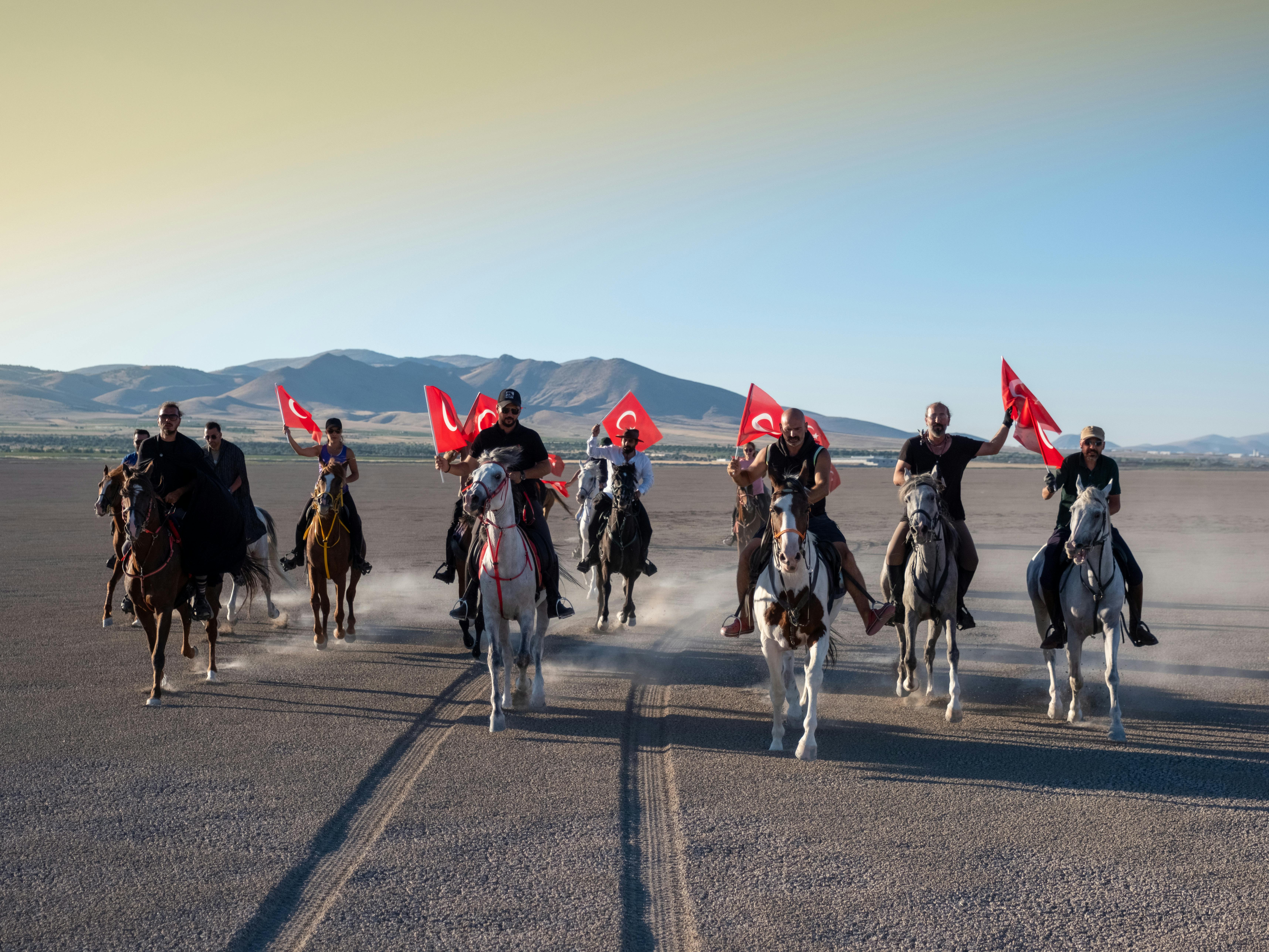 Men Riding Horses in the Desert with Turkish Flags in Hand · Free Stock ...