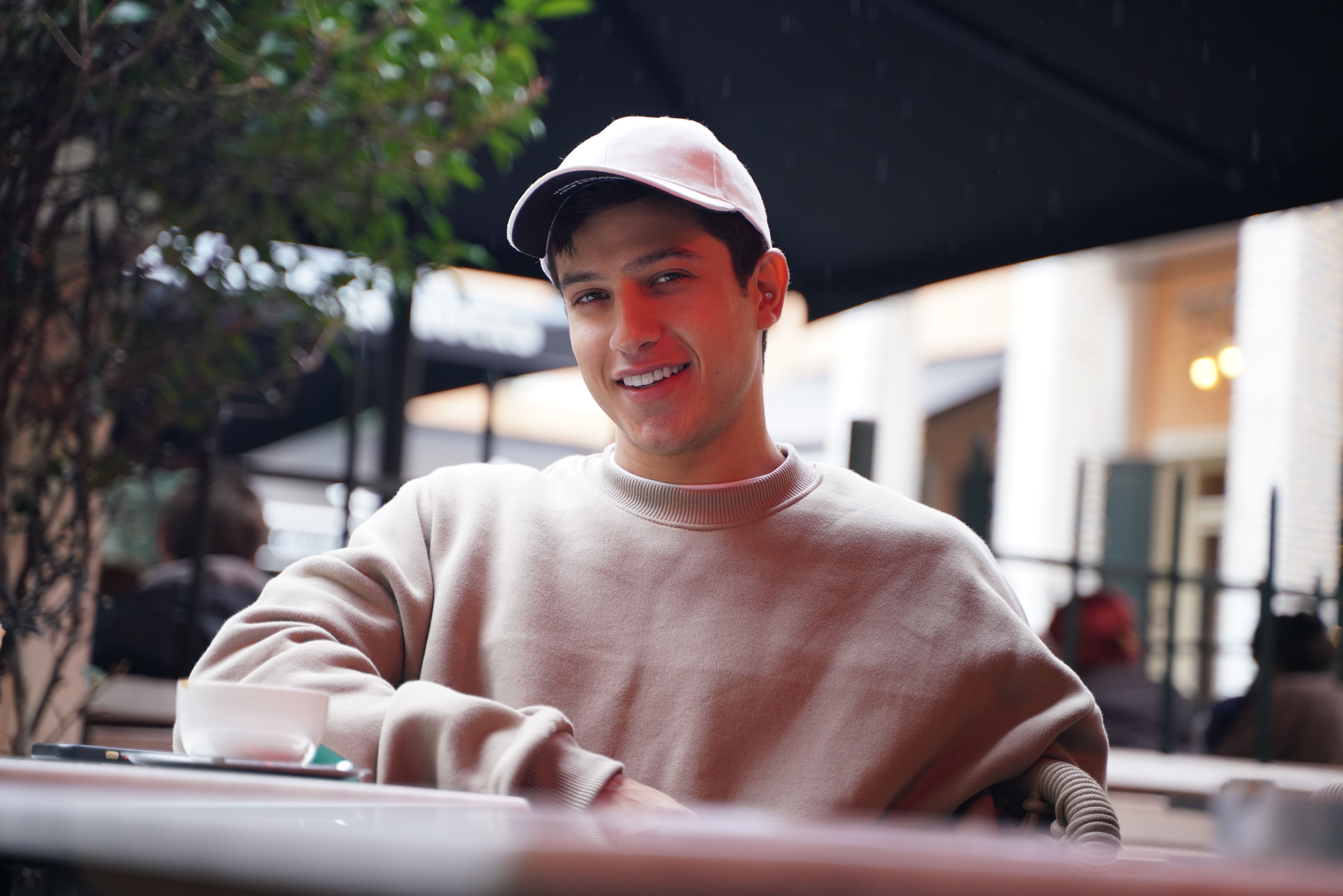 Smiling Man with White Cap in Cafe · Free Stock Photo