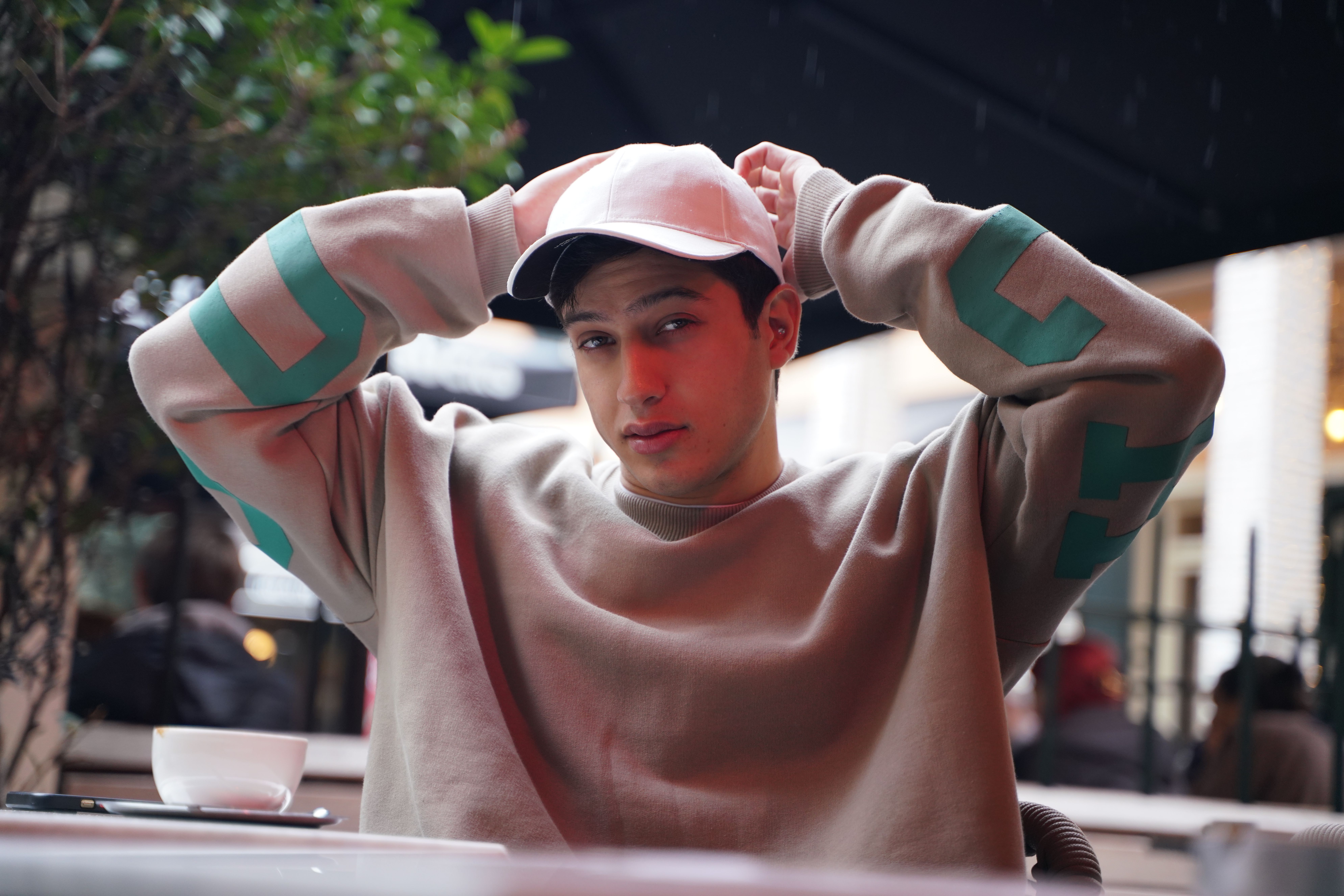 A Young Man in a Sweatshirt and a Full Cap · Free Stock Photo
