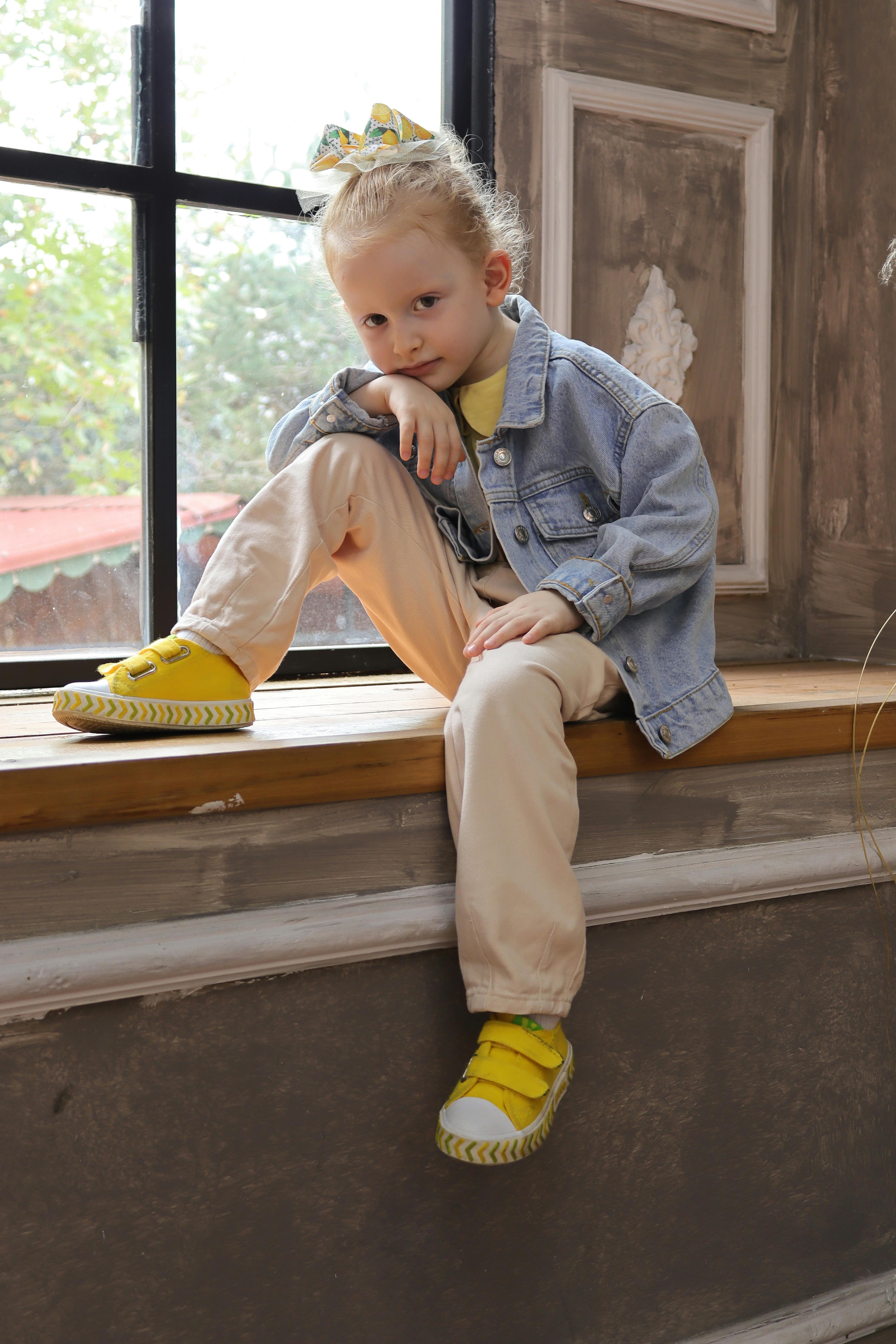 A Girl Sitting on a Window Sill · Free Stock Photo