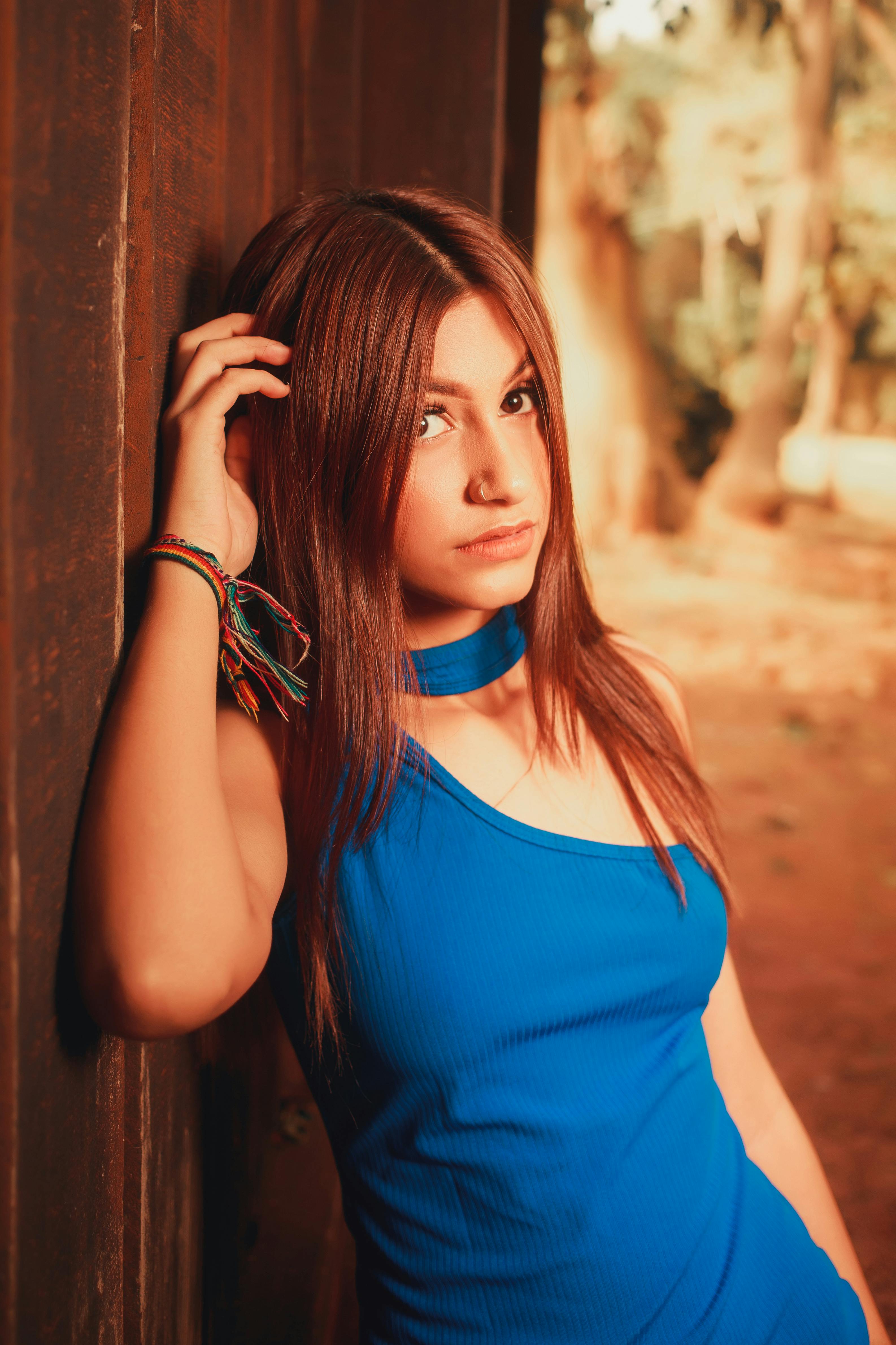 Beautiful Woman in a Blue Dress Fixing her Hair · Free Stock Photo