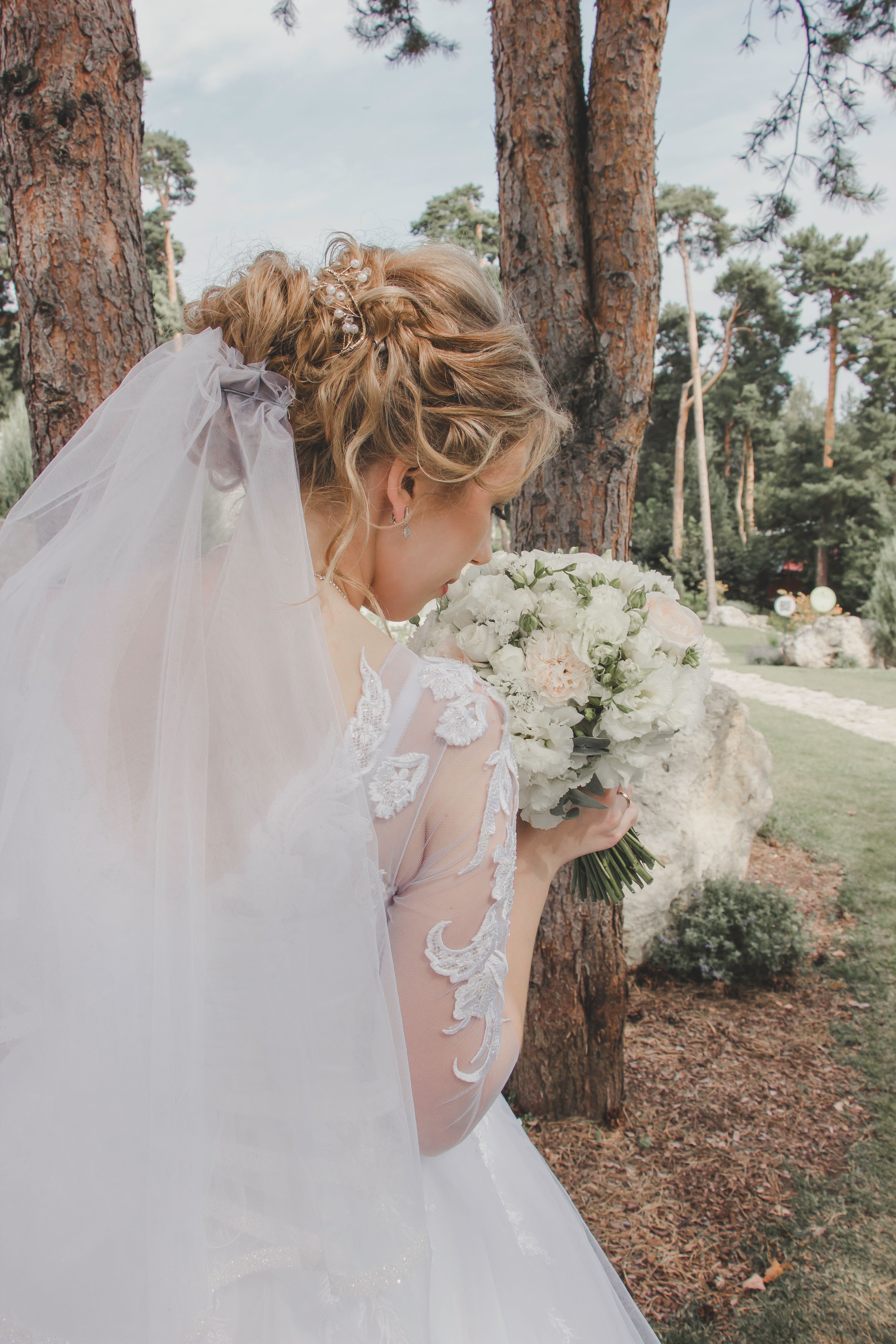 A Beautiful Bride Holding her Bridal Bouquet · Free Stock Photo