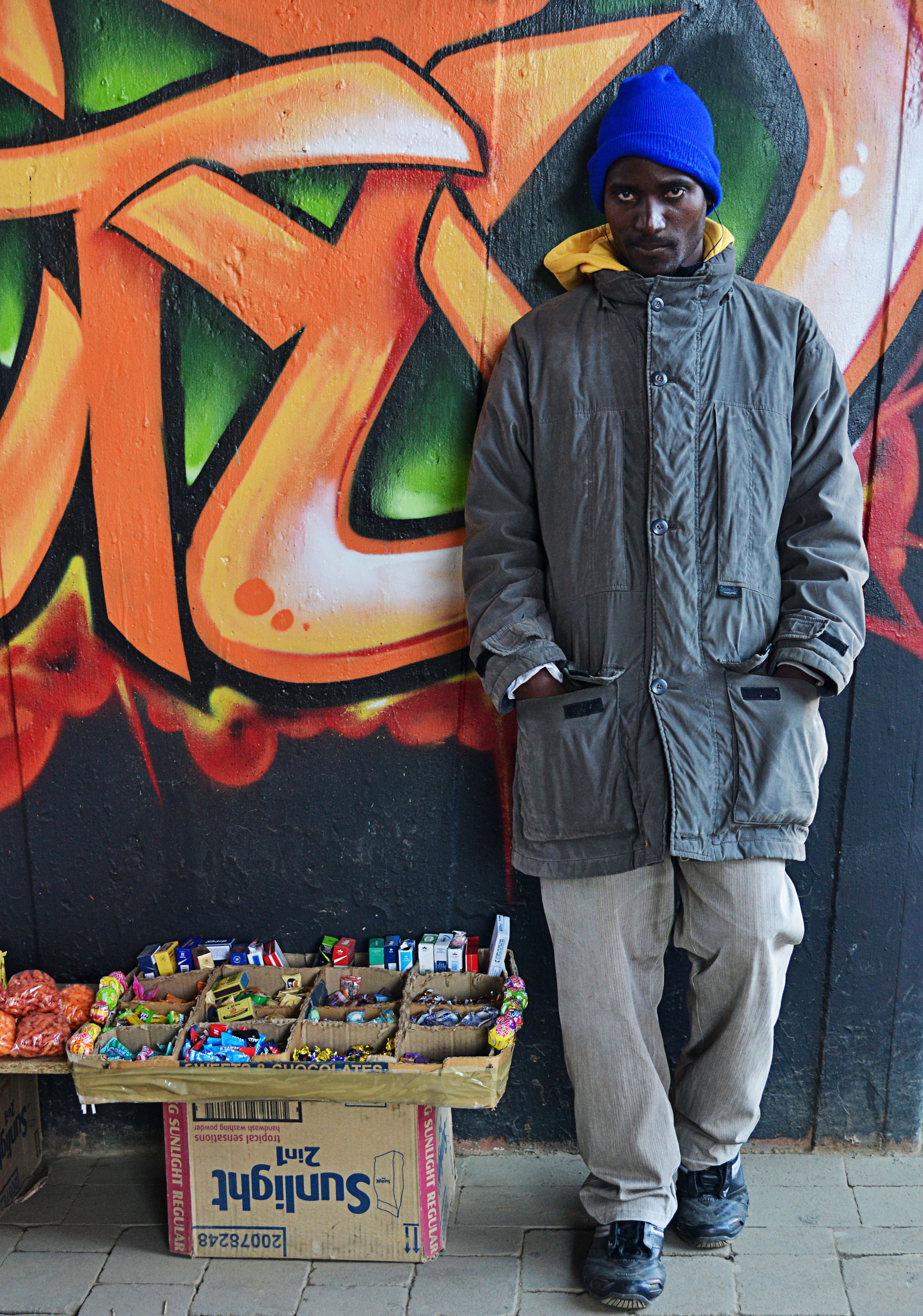 A Man Standing near a Wall with Graffiti and Selling Items · Free Stock ...