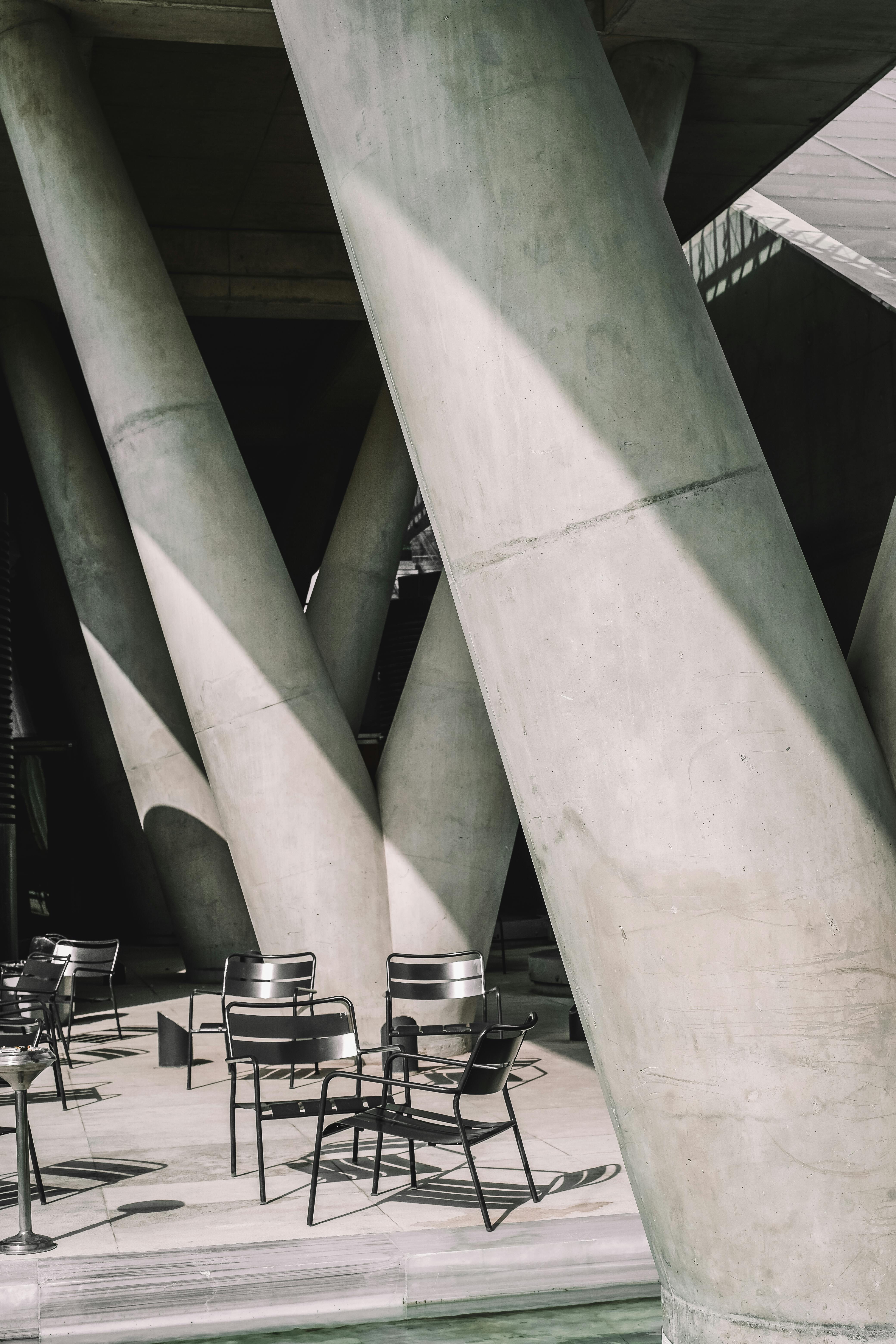 Tables and Chairs Standing between Large Concrete Columns · Free Stock ...