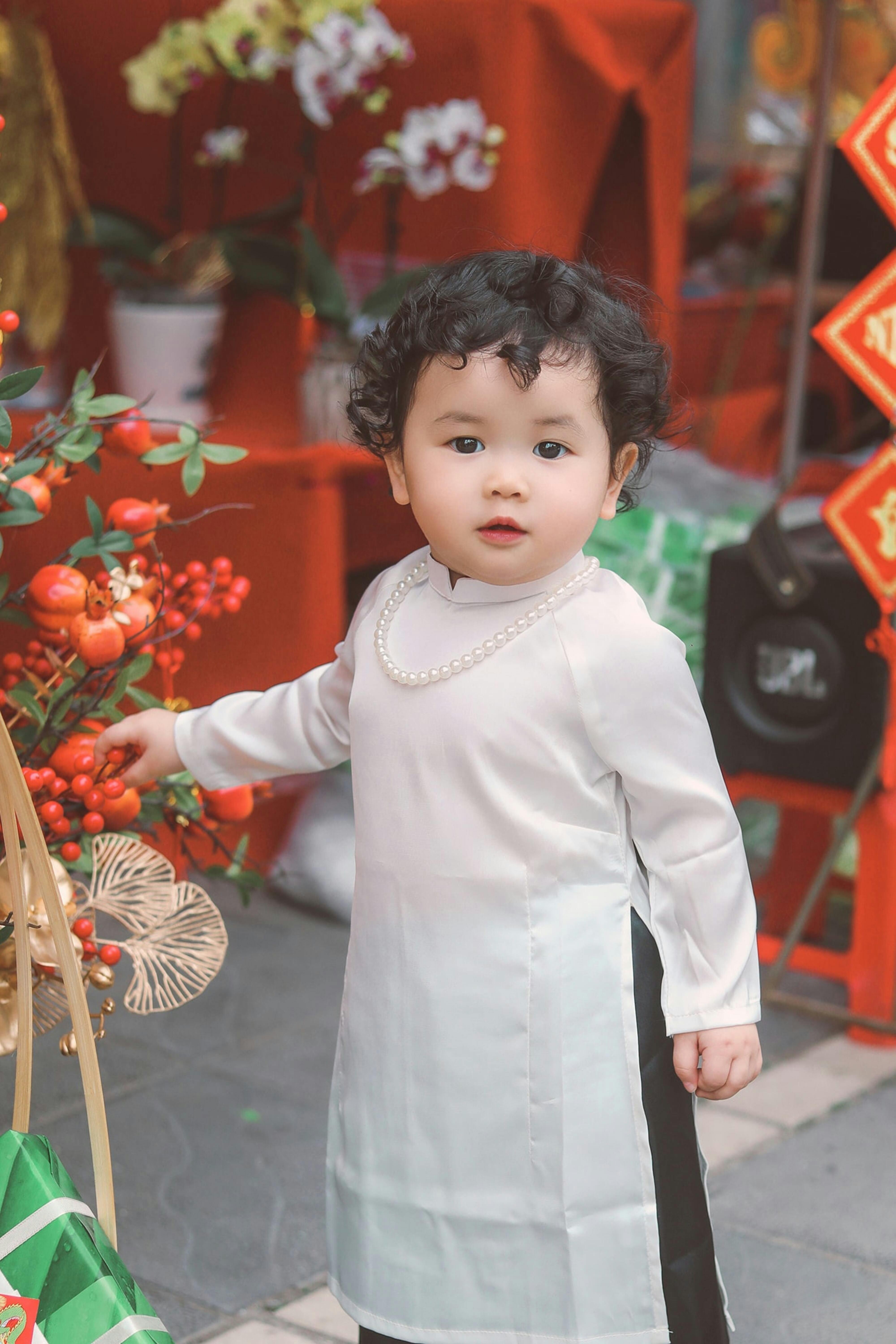 Little Boy in White Changpao Standing by Temple Entrance · Free Stock Photo