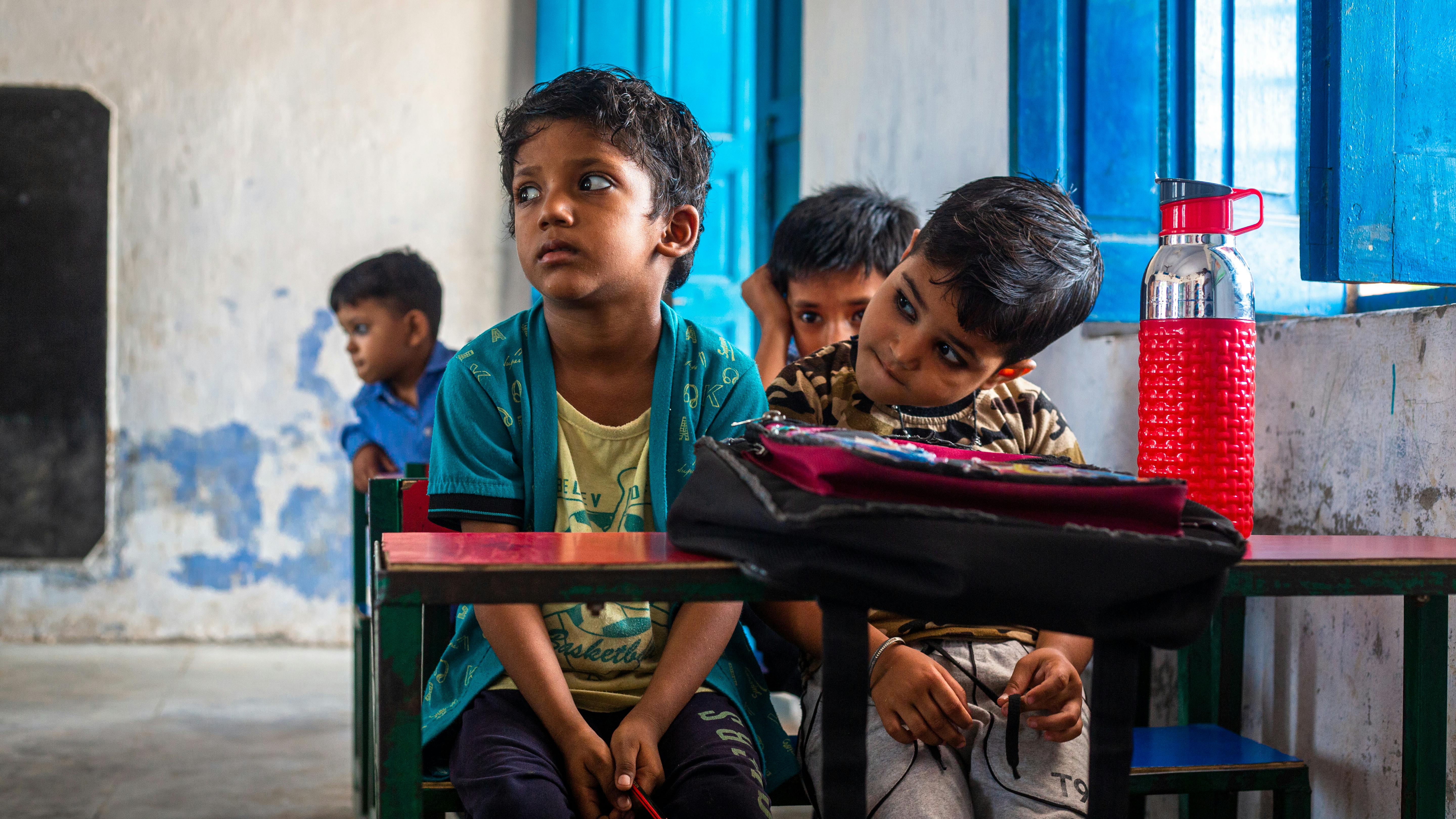 Two children sit at desks in a classroom · Free Stock Photo