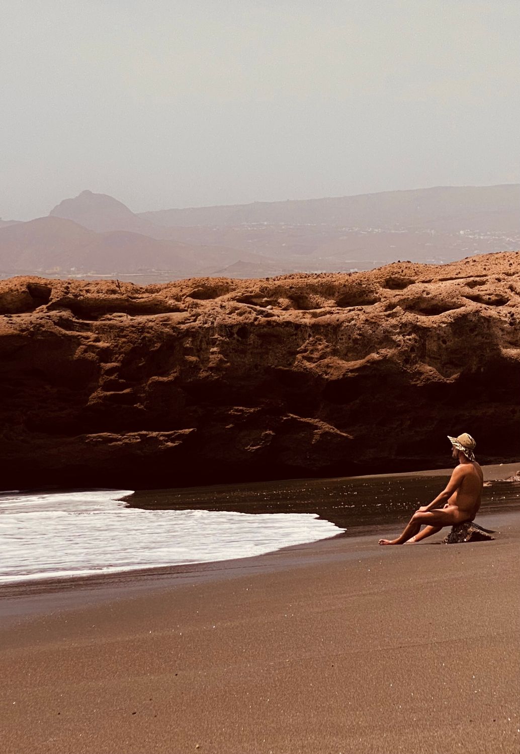 Un Hombre Sentado En La Playa · Foto de stock gratuita