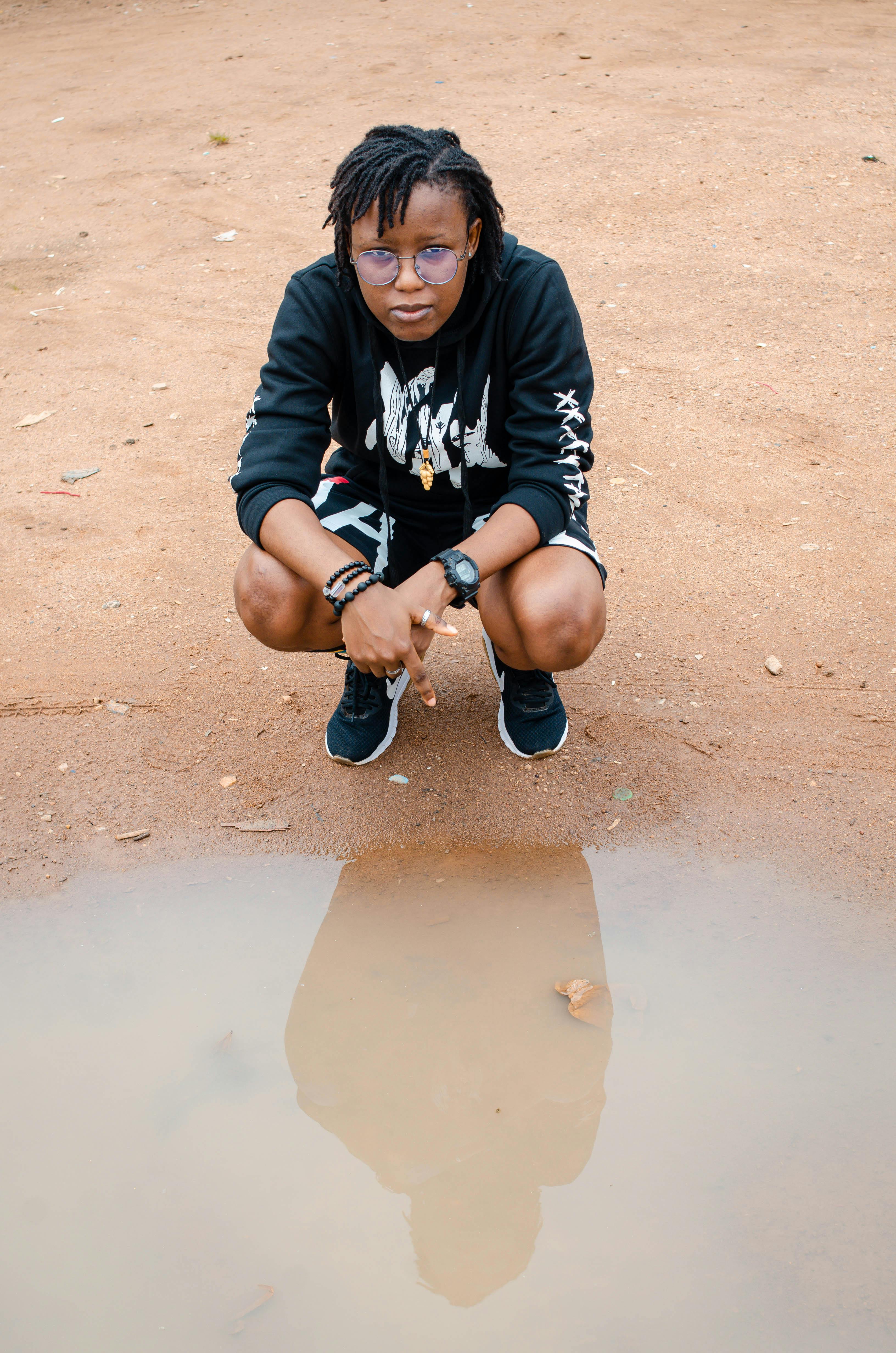 Man Crouching on City Street · Free Stock Photo
