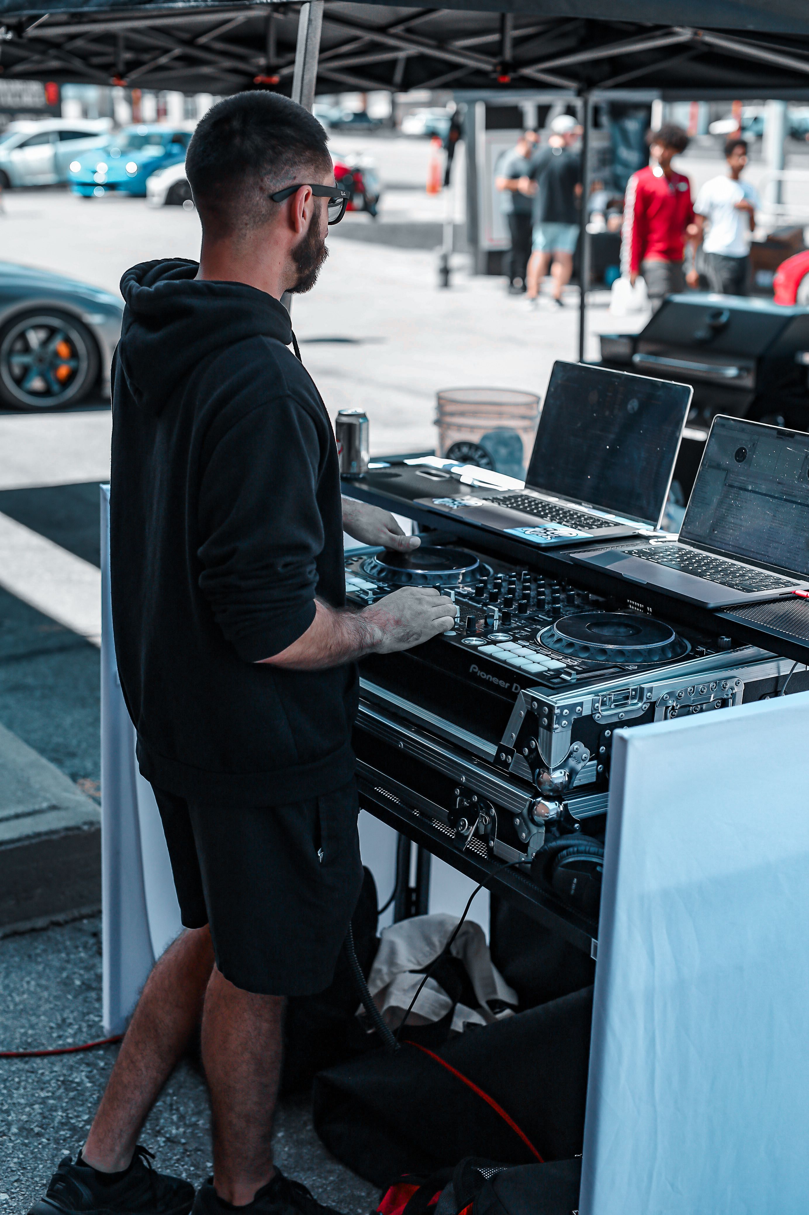 Man Using DJ Mixer by the Parking Lot · Free Stock Photo