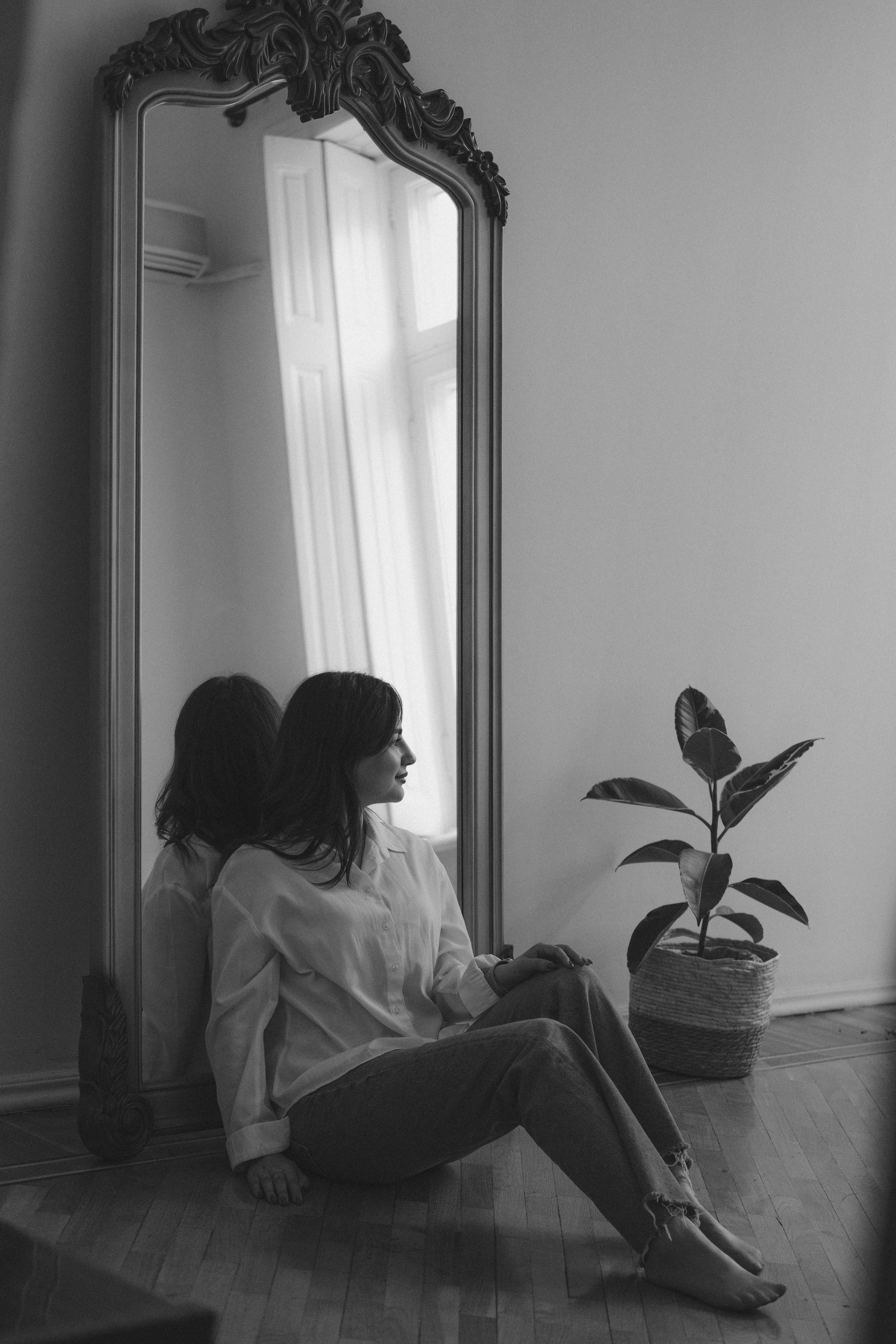 Young Woman Sitting on the Floor by the Mirror in a Room · Free Stock Photo